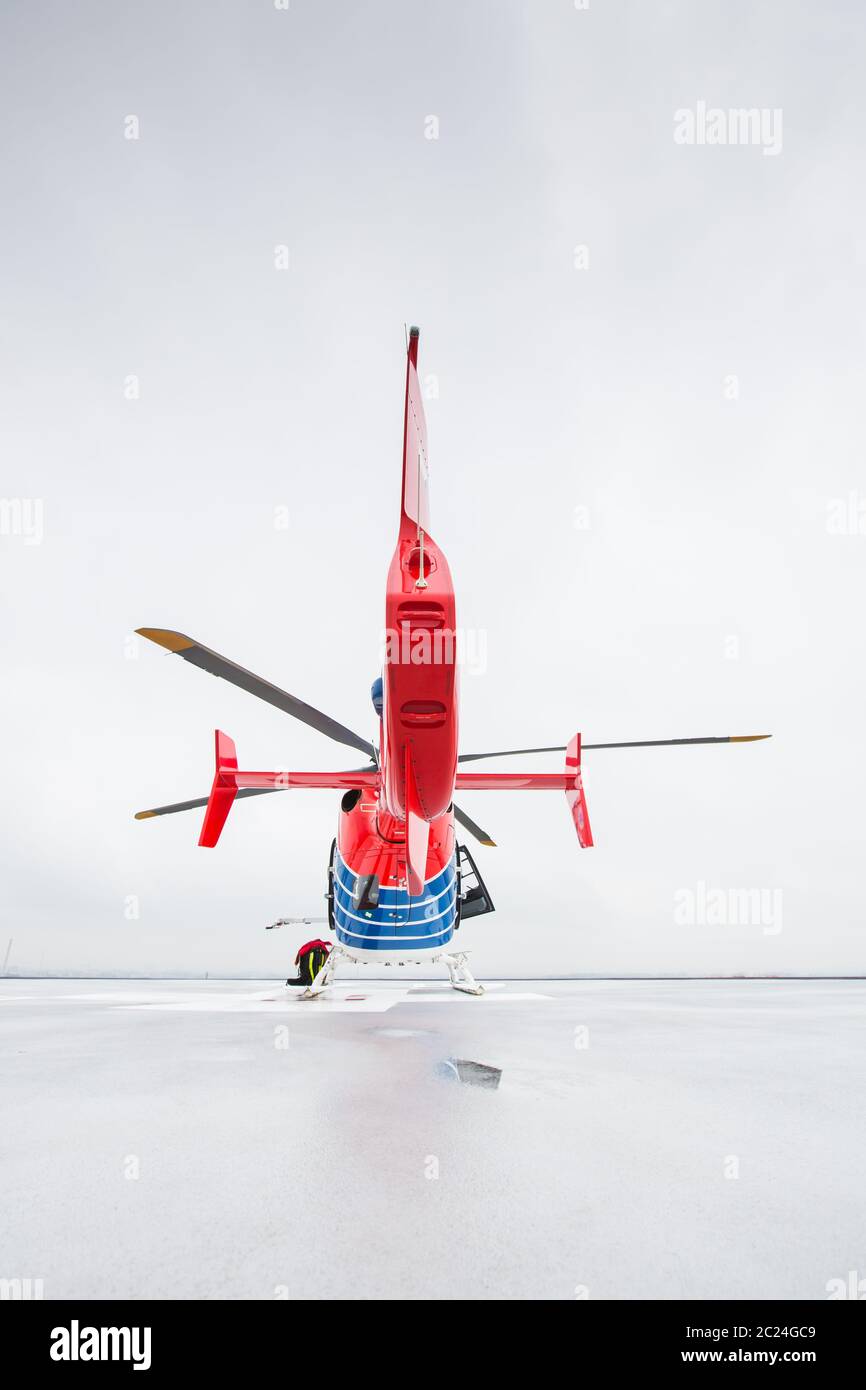 Modern medical helicopter on a hospital rooftop helipad from behind ...