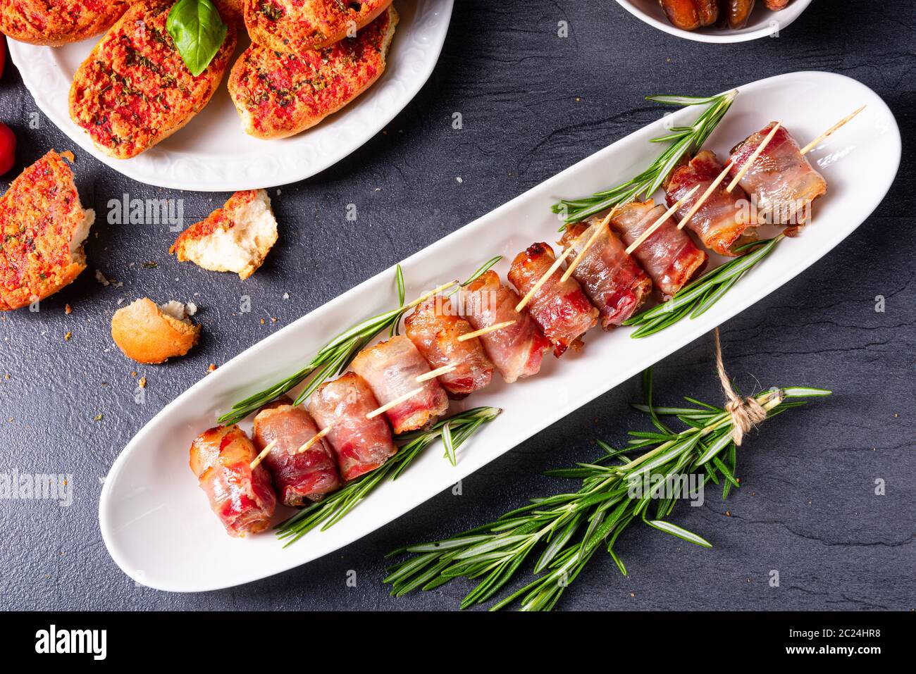 dates wrapped in bacon and delicious tapas Stock Photo - Alamy
