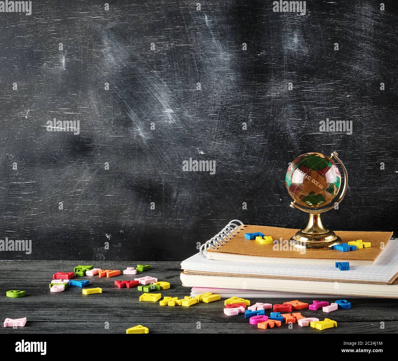 glass globe is standing on a stack of notebooks on the background of a ...