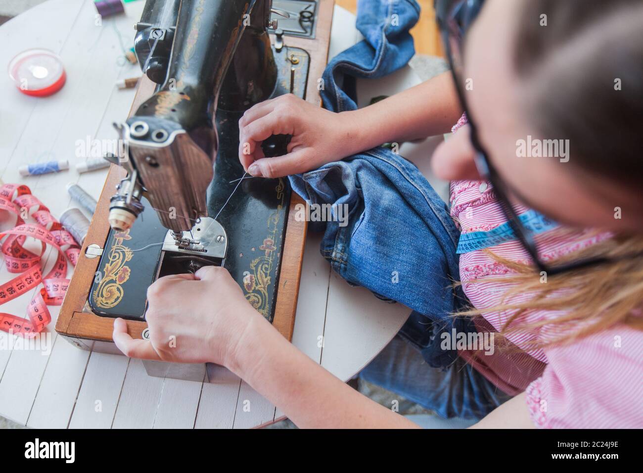 Top view of female tailor working with old vintage sewing machine at ...
