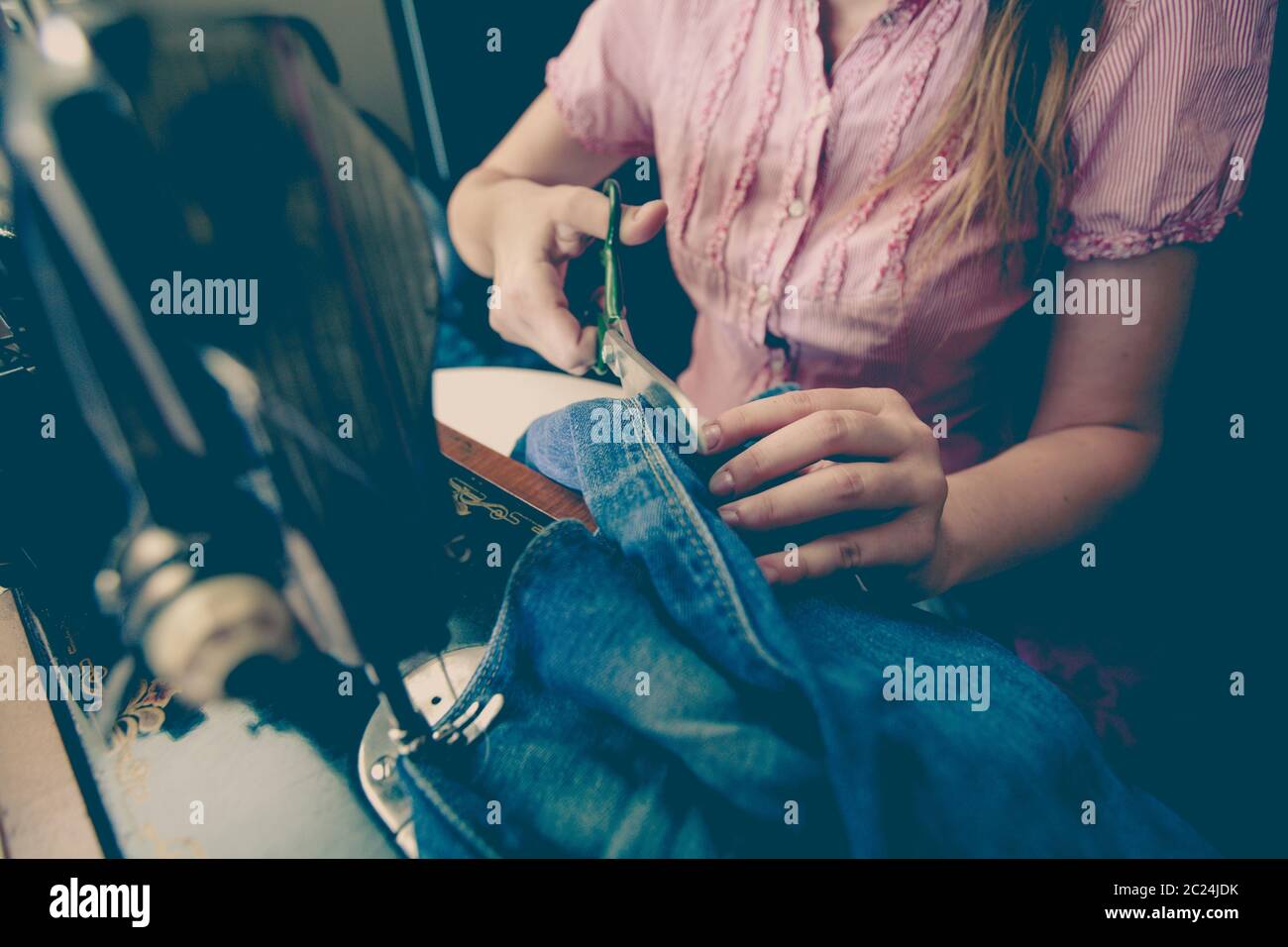 Female hands using scissors for cutting blue jeans and retro sewing ...