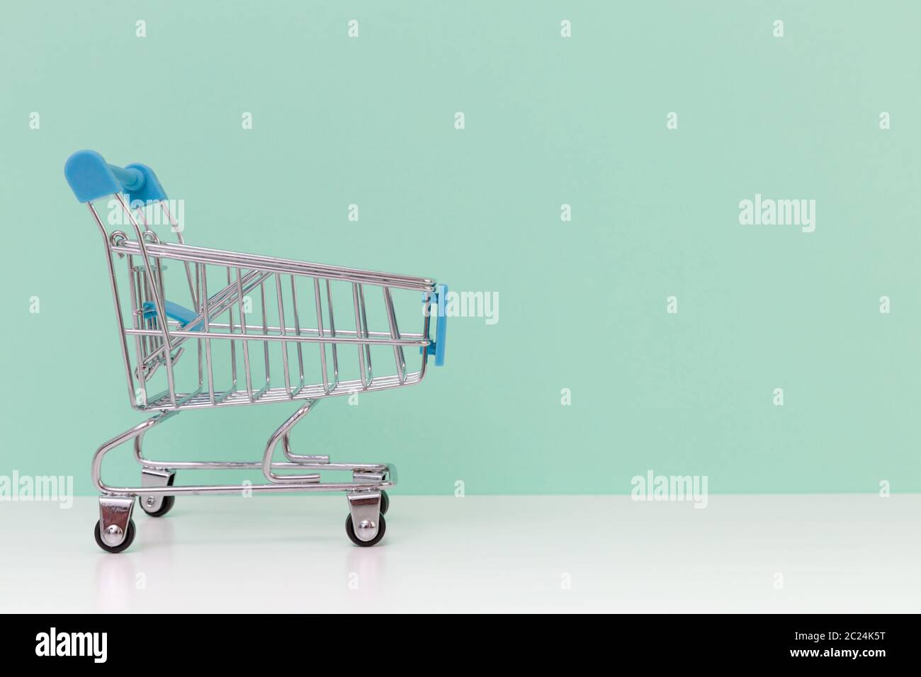 Empty shopping cart on light blue background Stock Photo - Alamy