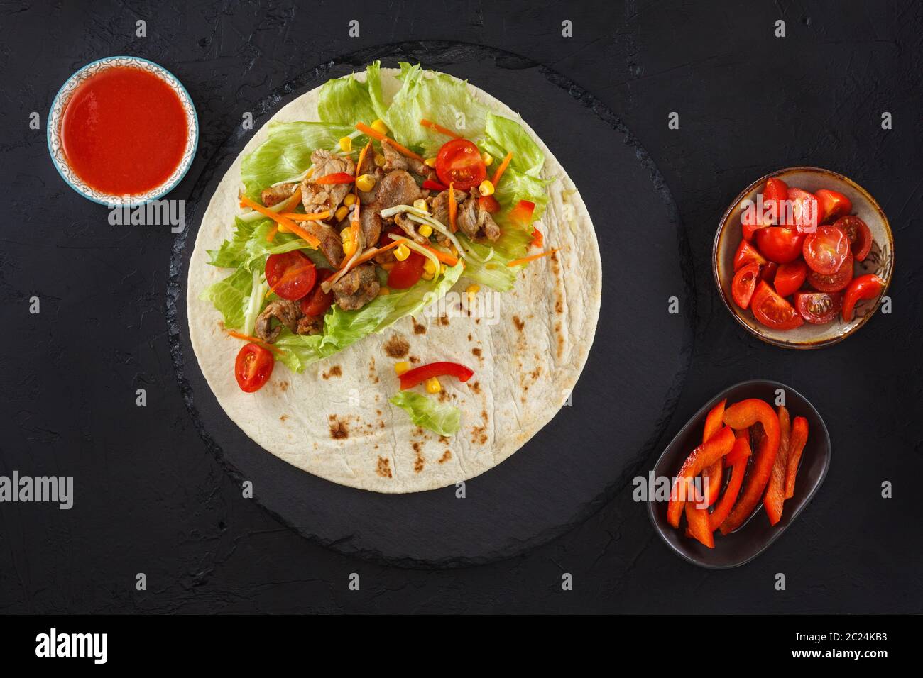 Burritos wraps with chicken and vegetables on black slate. Chicken burrito, mexican food Stock ...