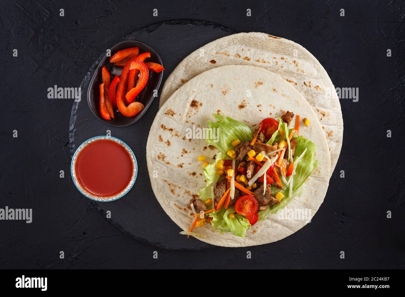 Burritos wraps with chicken and vegetables on black slate. Chicken burrito, mexican food Stock ...