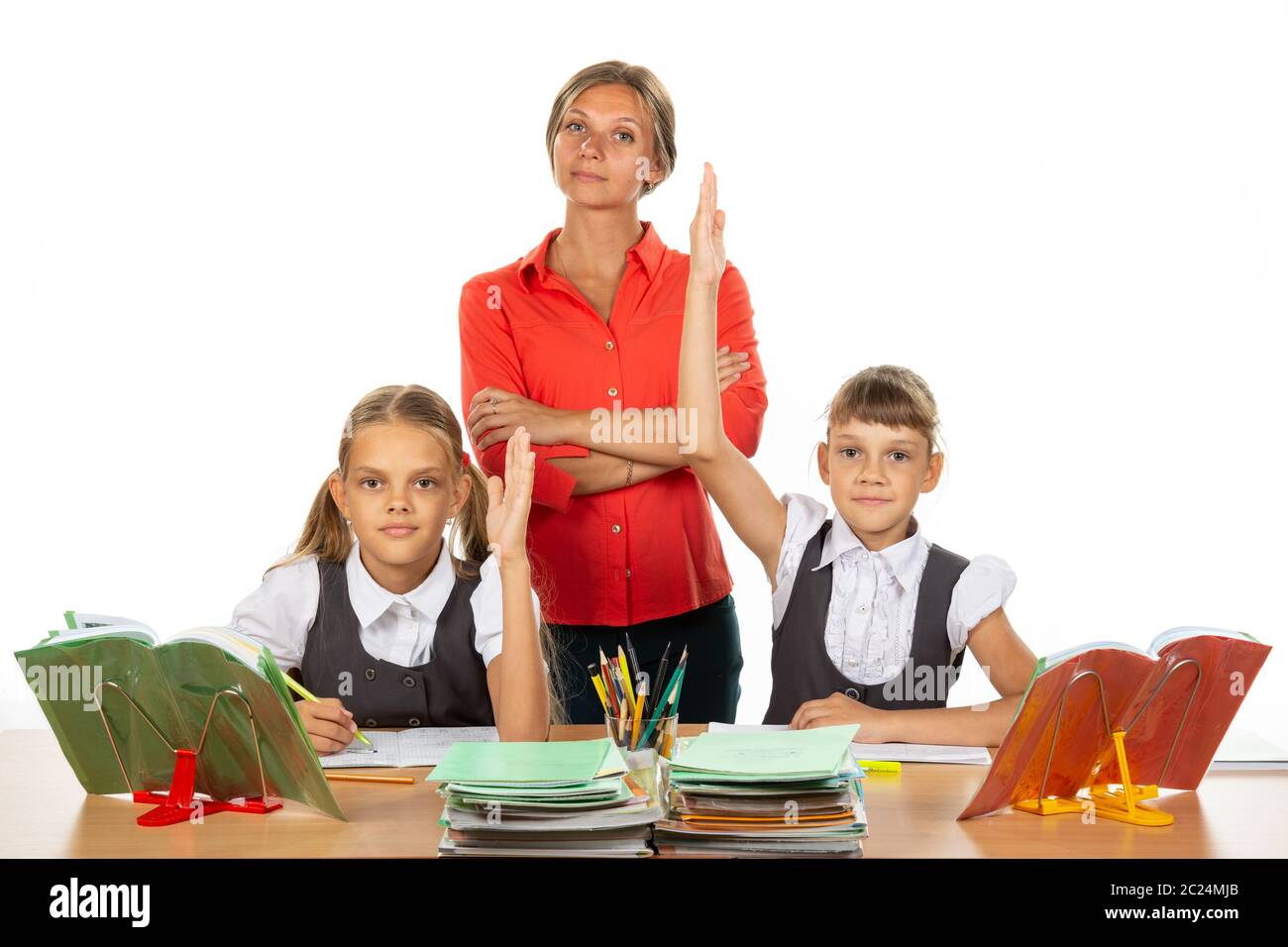 Children pull their hands up, ready to answer a question, in the ...