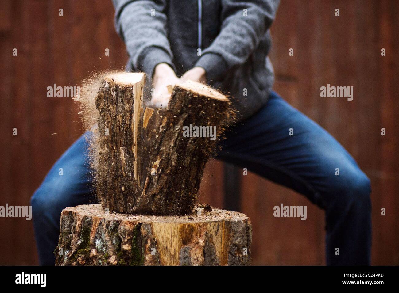 The lumberjack is cutting wood or firewood with axe on brown background ...