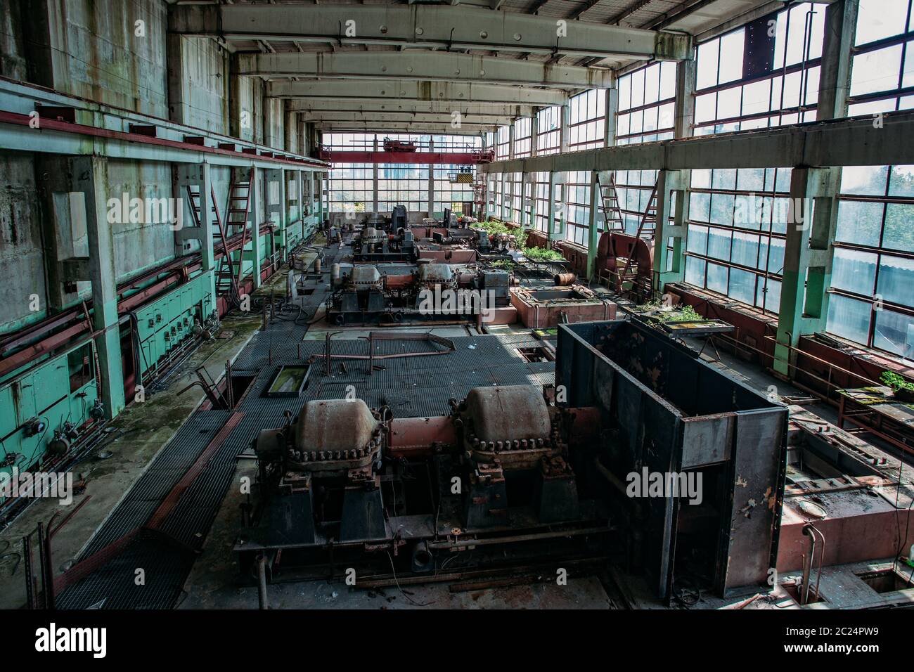 Old abandoned overgrown factory with rusty remains of industrial ...