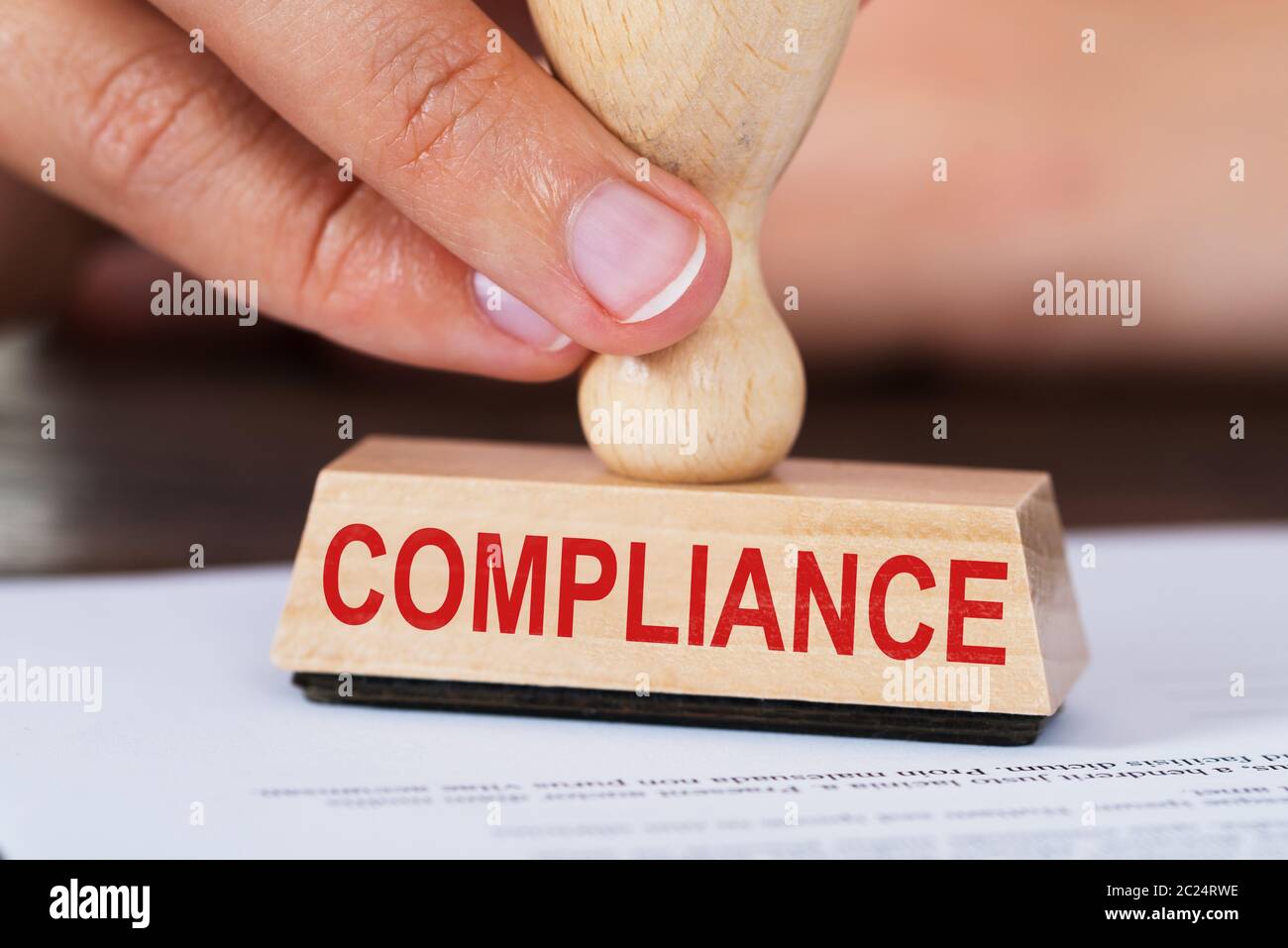 Close-up Of A Businessperson's Hand Stamping Compliance On Paper In ...