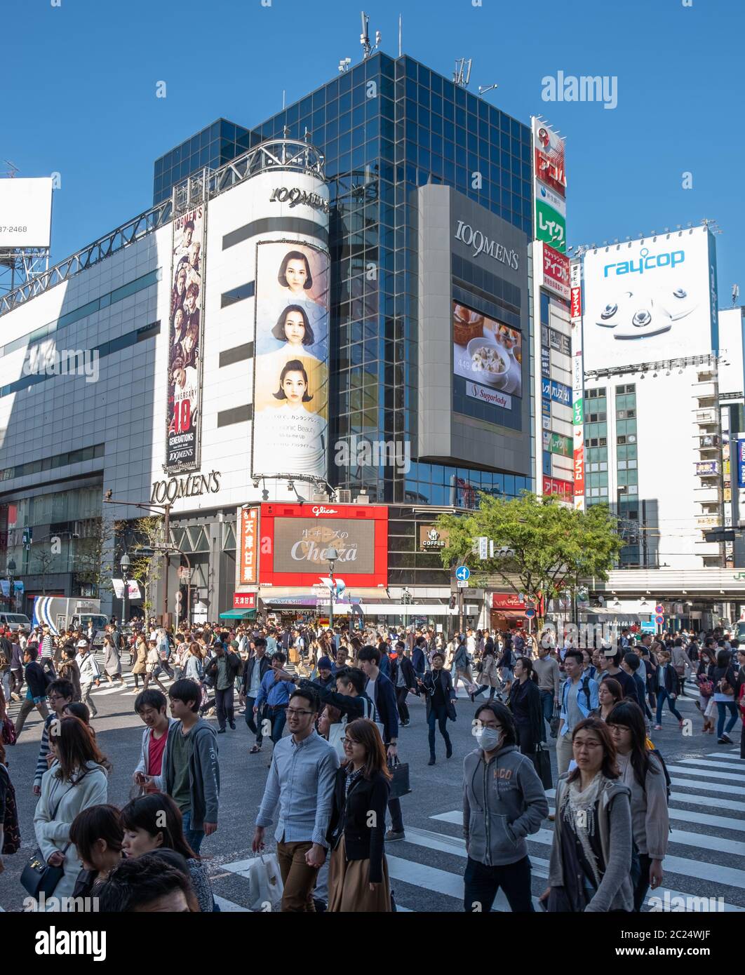 Mass crowd walking across the famous Shibuya pedestrian scramble ...