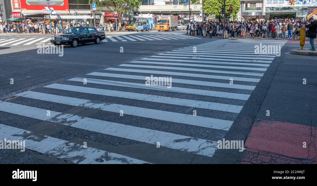 Mass crowd walking across the famous Shibuya pedestrian scramble ...