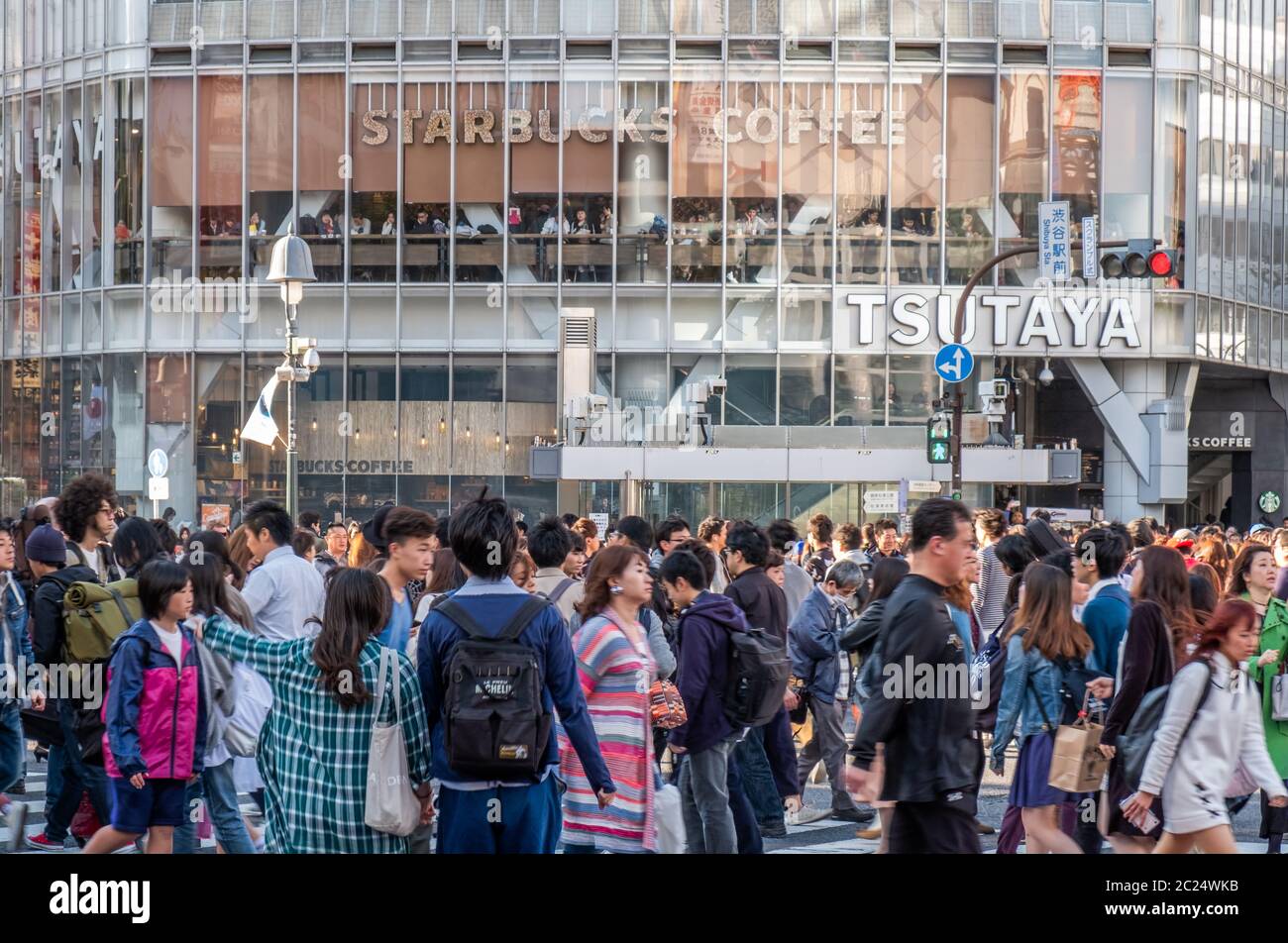 Mass crowd walking across the famous Shibuya pedestrian scramble ...