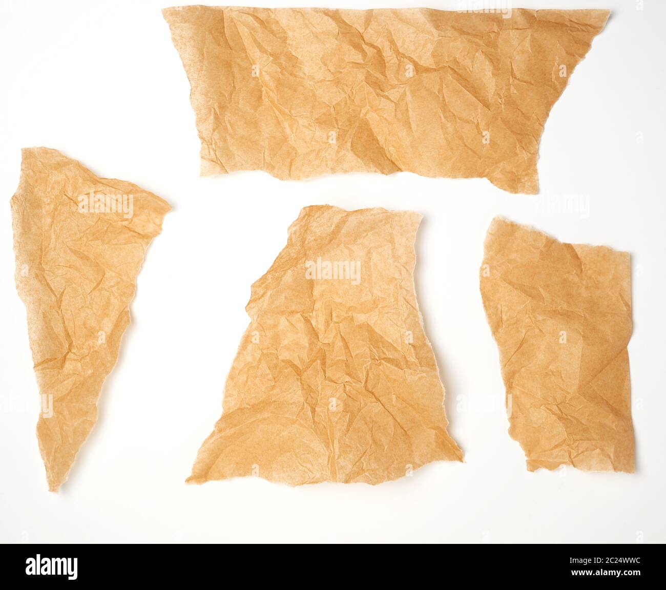 torn brown pieces of parchment paper on a white background, flat lay ...