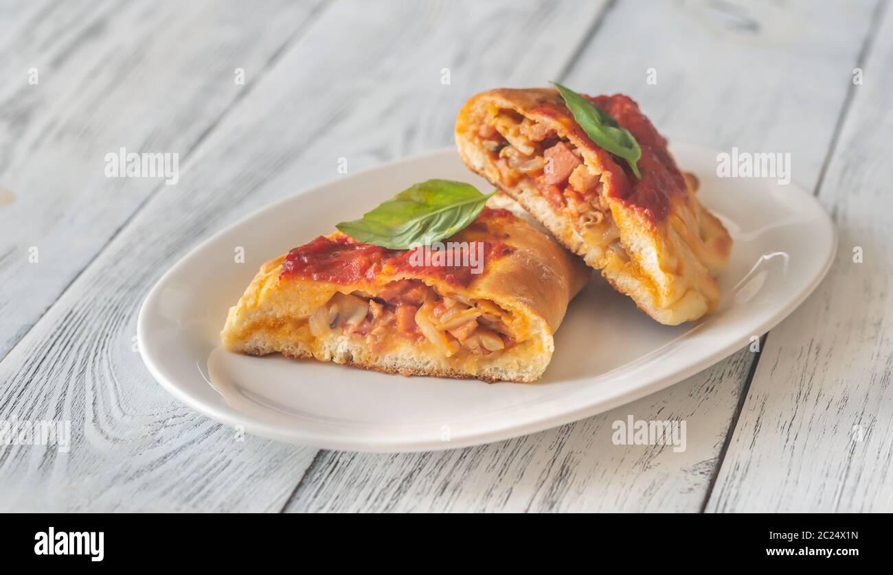 Homemade calzone stuffed with pancetta and mushrooms: cross section ...