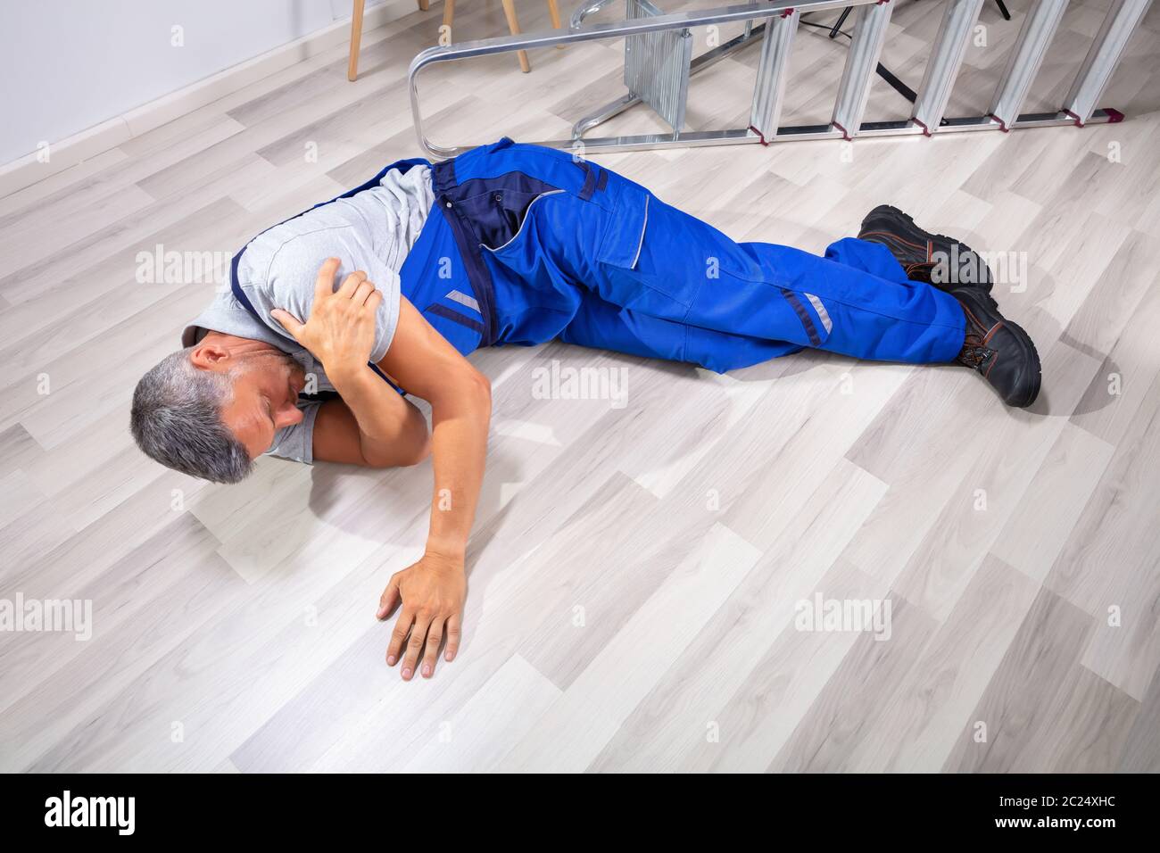 Handyman Fallen From Ladder Lying On Floor Stock Photo - Alamy