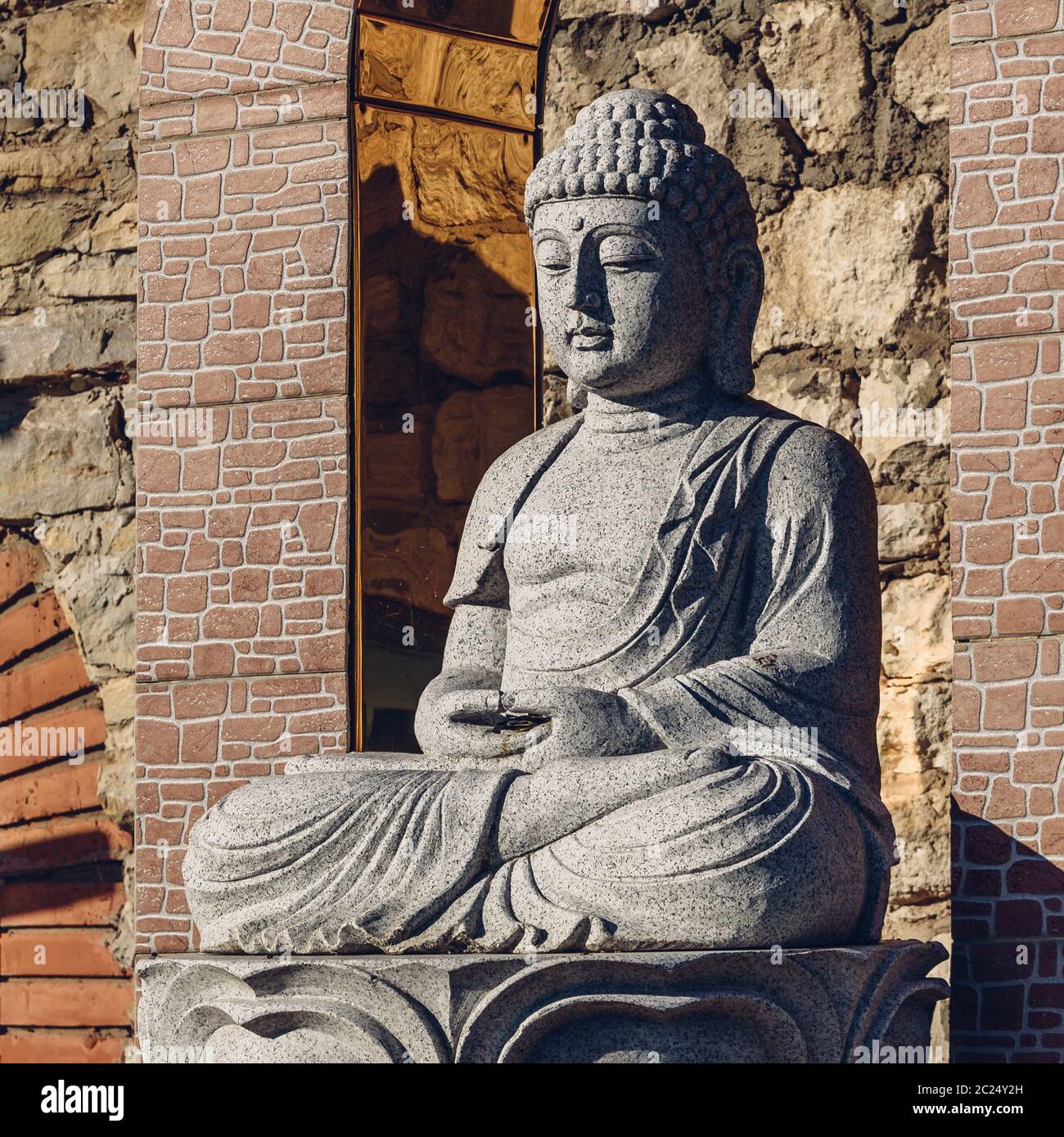 White stone statue of a Buddha on masonry background Stock Photo - Alamy