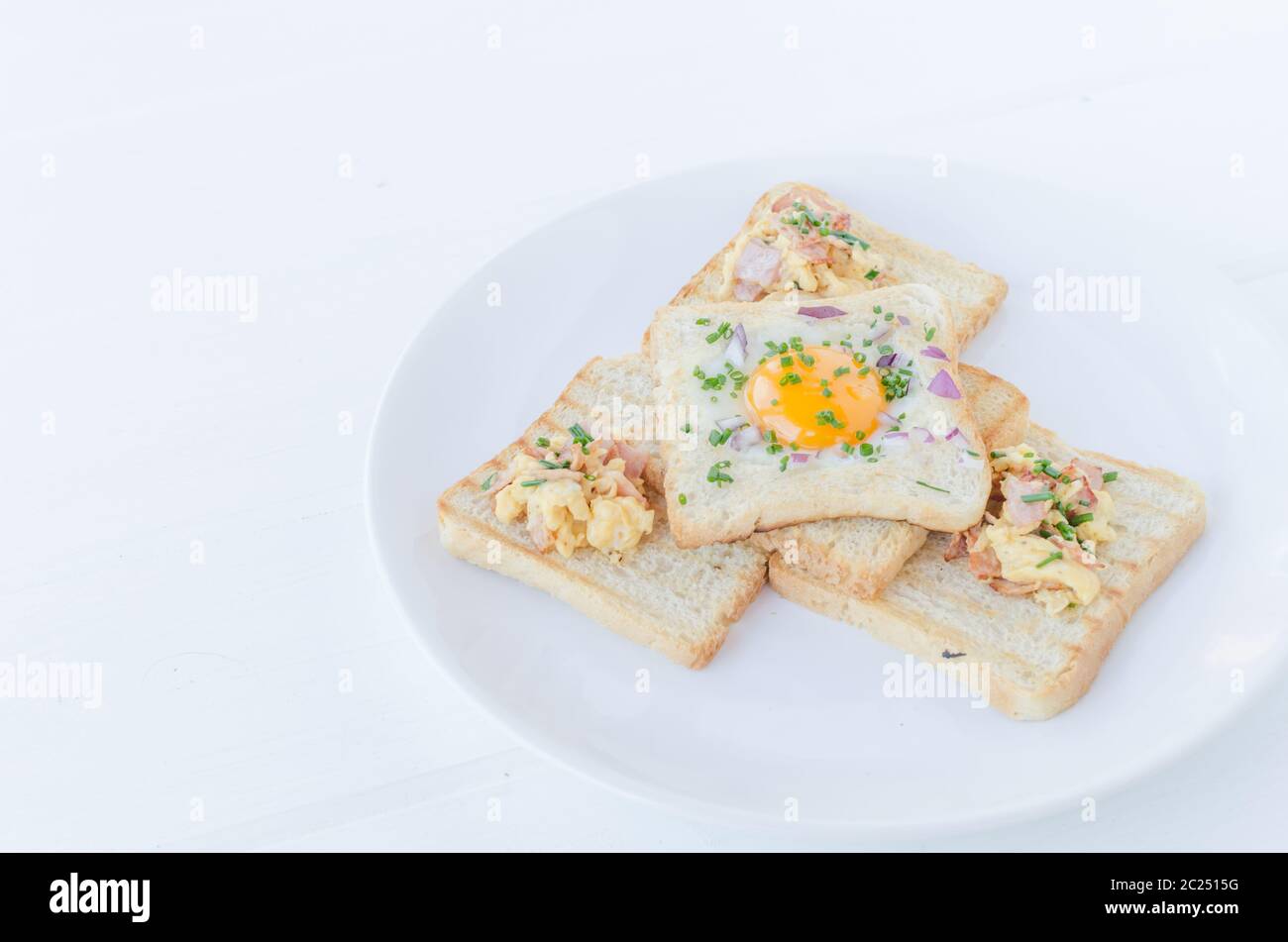 Fried egg inside toast with chive, ham and scrambled eggs Stock Photo ...