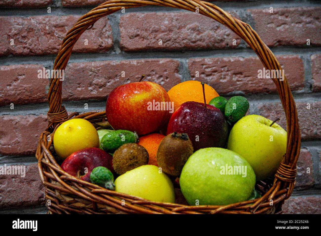 Mixed exotic fruit basket in brick background Stock Photo - Alamy