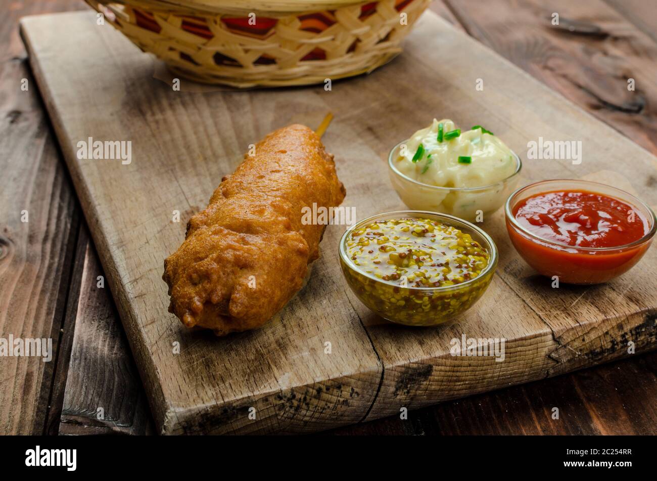 Corn dog with three sauces, chilli, mayonnaise with herbs and whole ...