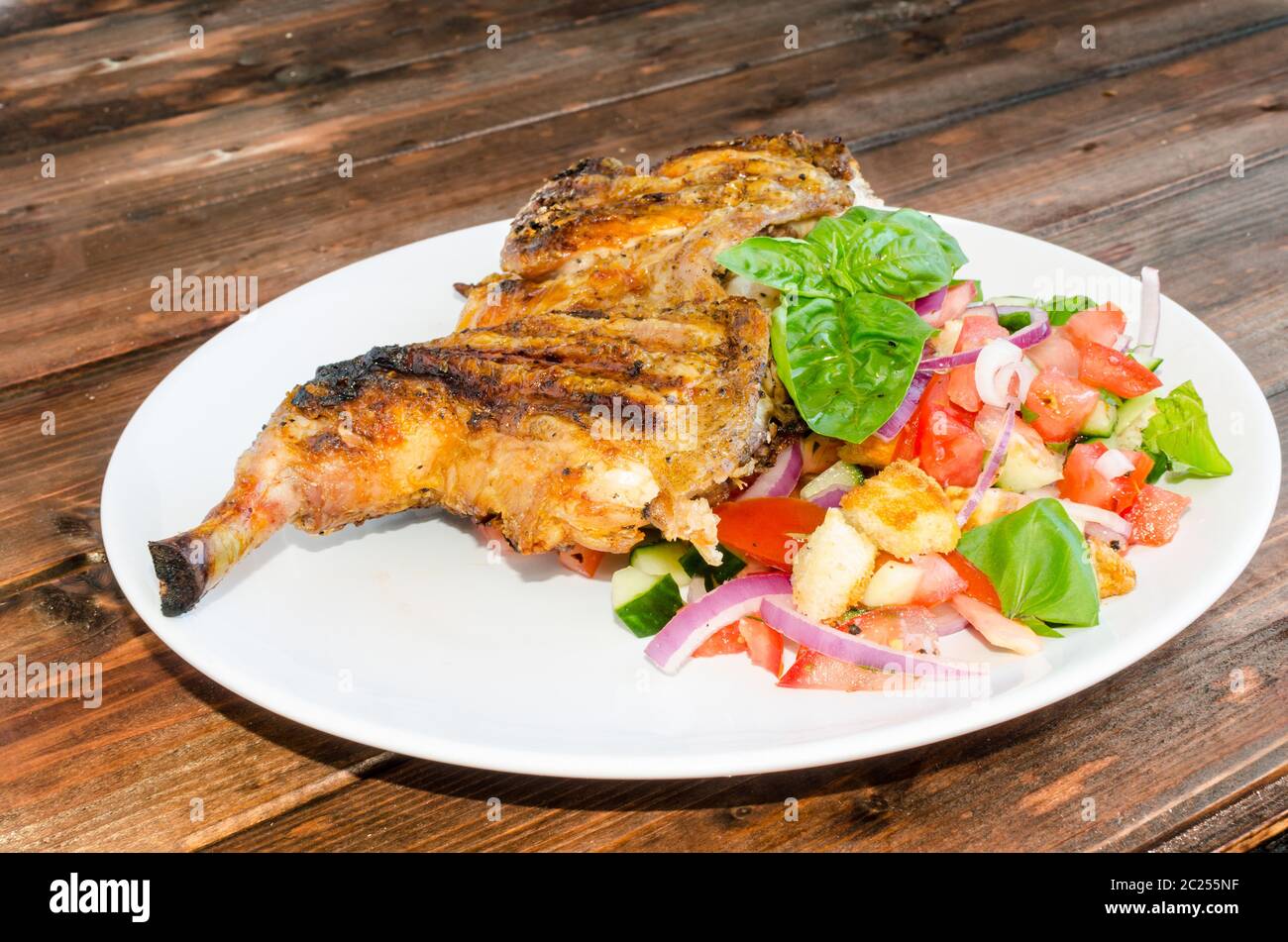 Chicken under a brick with panzanella salad. Pollo al mattone Stock ...