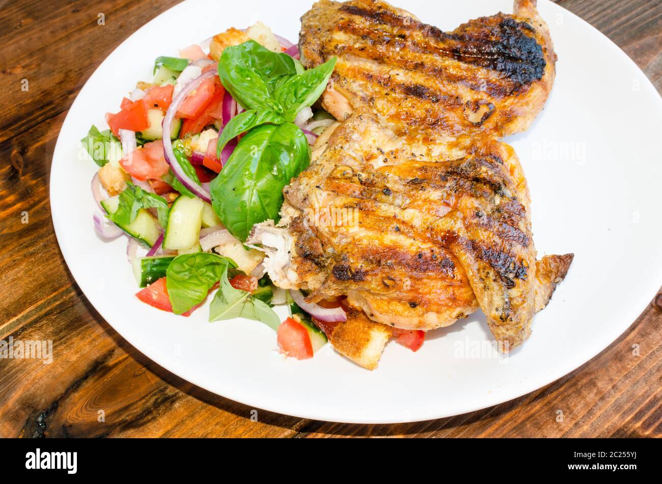 Chicken under a brick with panzanella salad. Pollo al mattone Stock ...