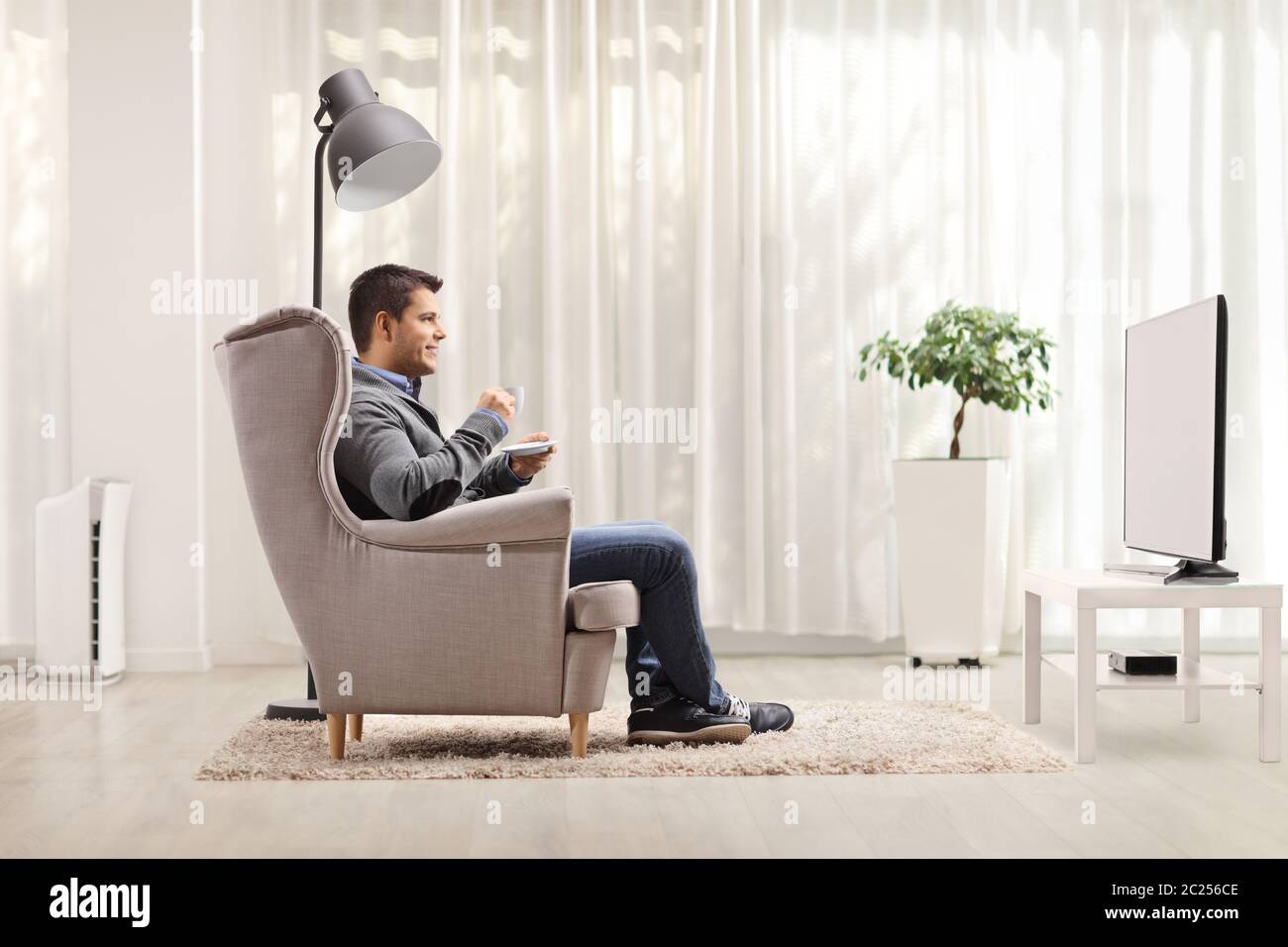 Man watching tv drinking coffee hi-res stock photography and images - Alamy