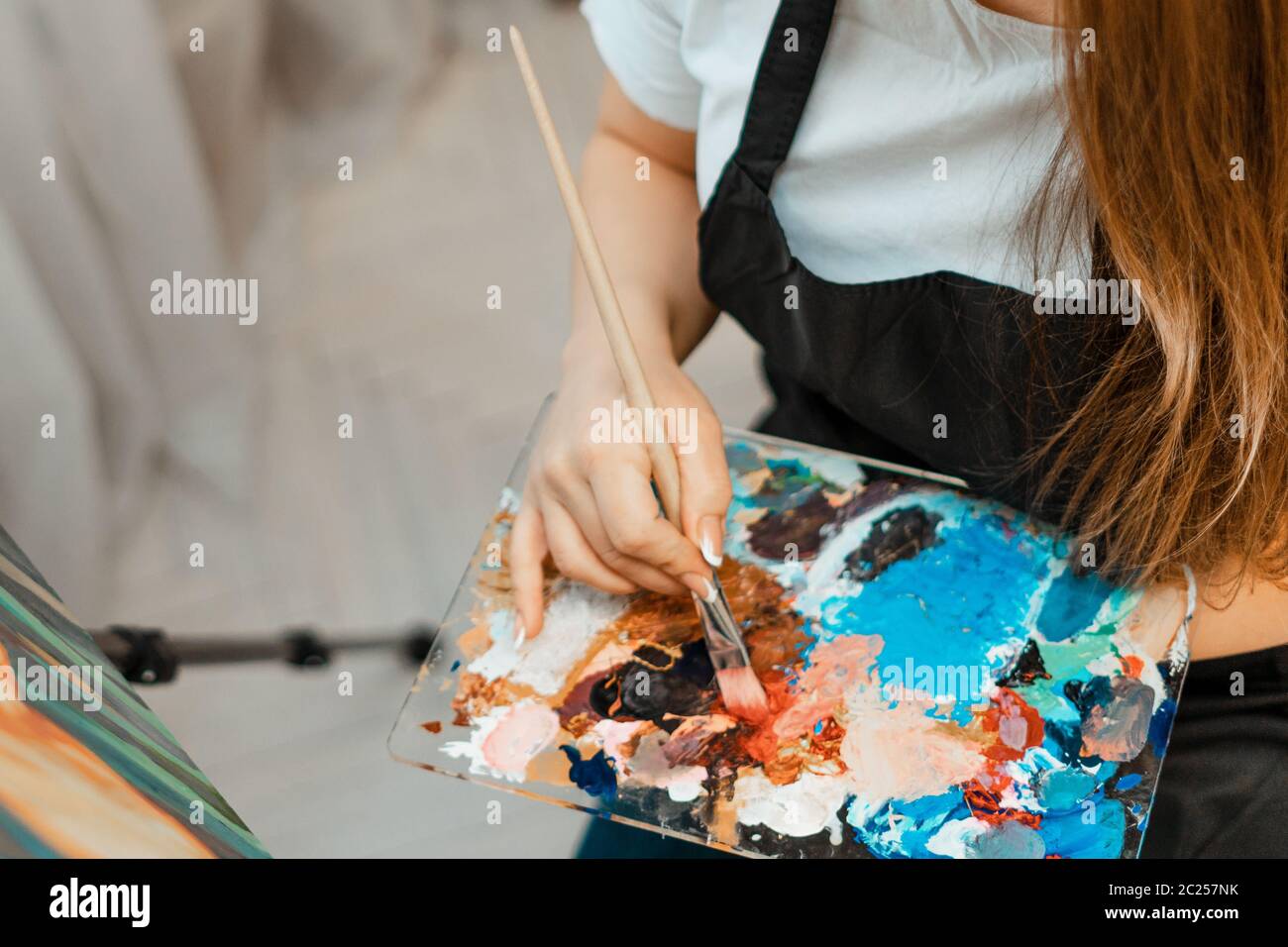 Art, the work of the artist. Young beautiful girl artist paints a ...