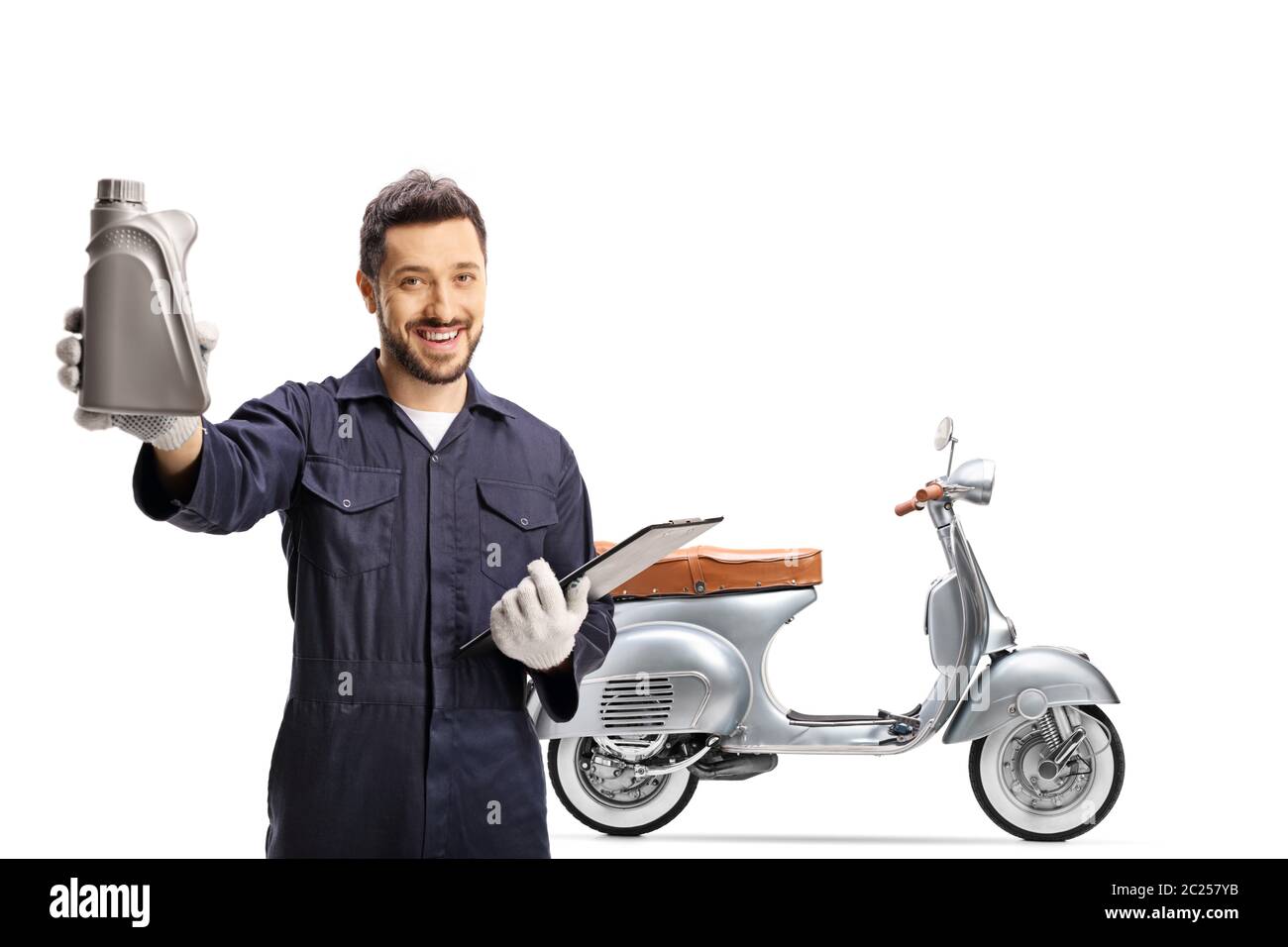 Motorbike mechanic with a vintage scooter holding a bottle of motor oil ...