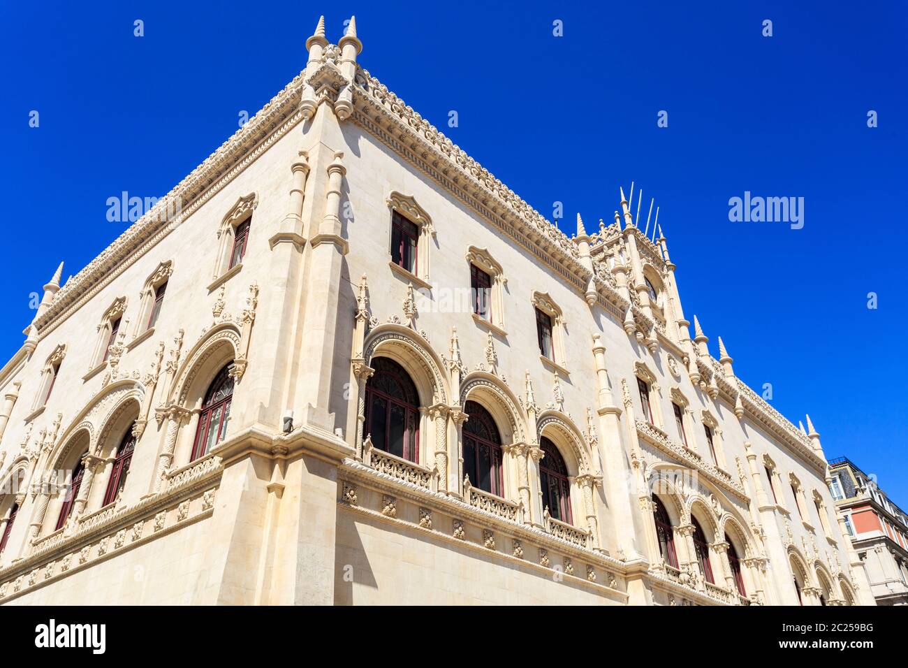 People in front of the Neo-Manueline style facade of Rossio railway ...