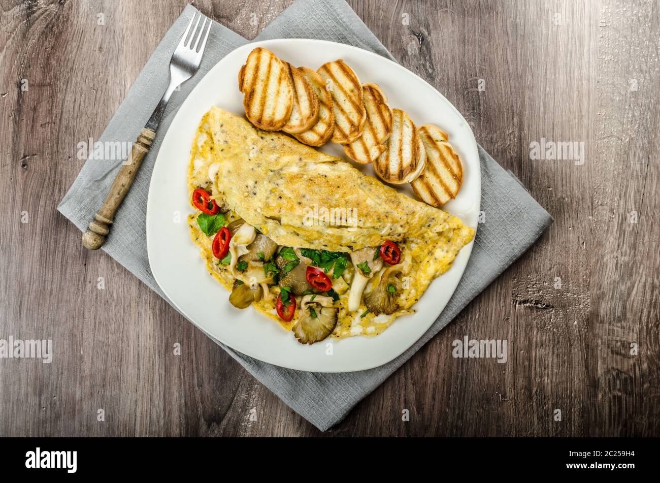 Rustic vegetarian omelette with chili peppers and mushrooms Stock Photo ...