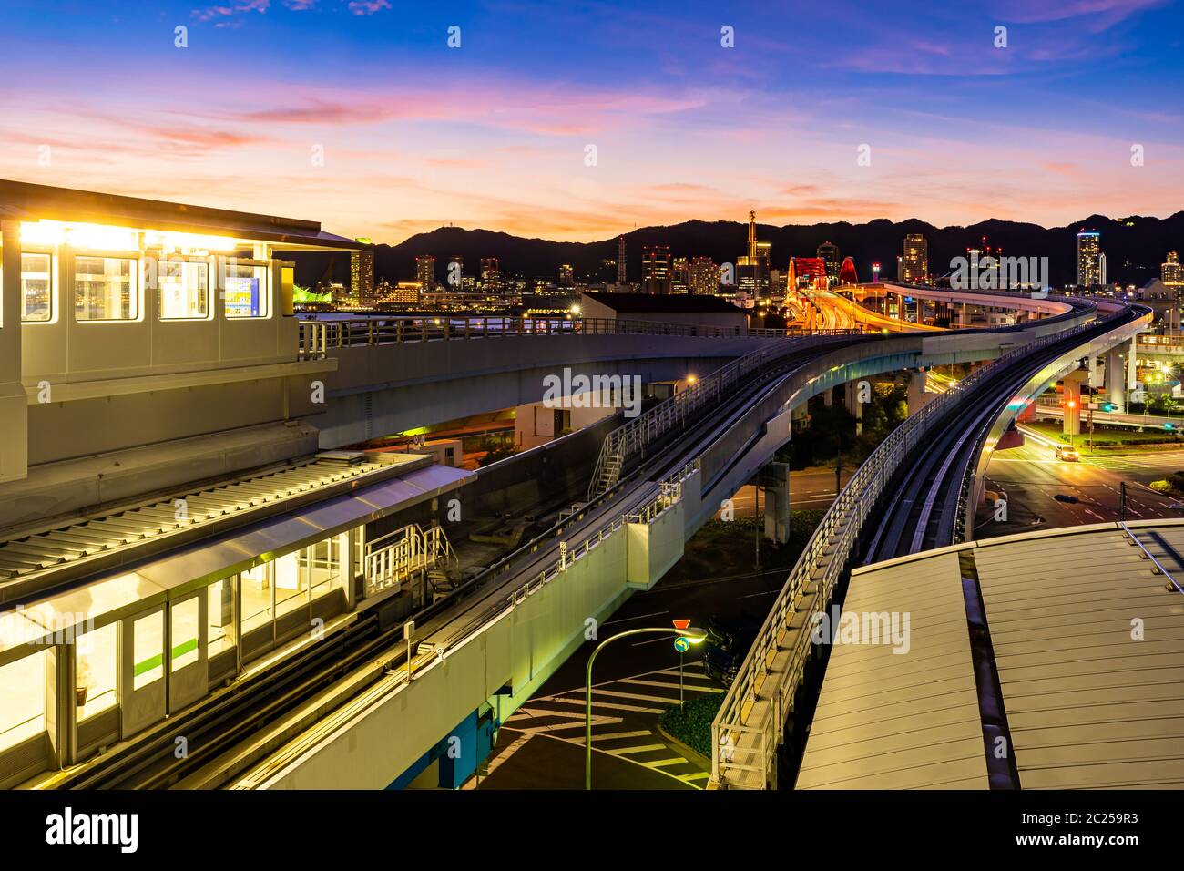 Sunset twilight monorail track and highway red bridge to Kobe downtown ...