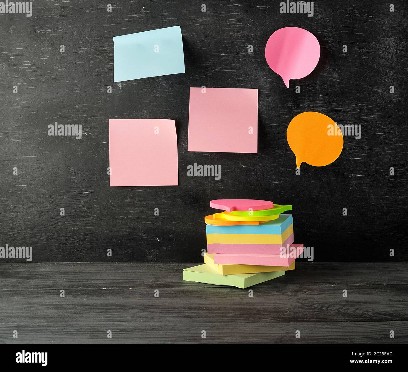 stack of multi-colored sticky stickers on a black wooden background ...