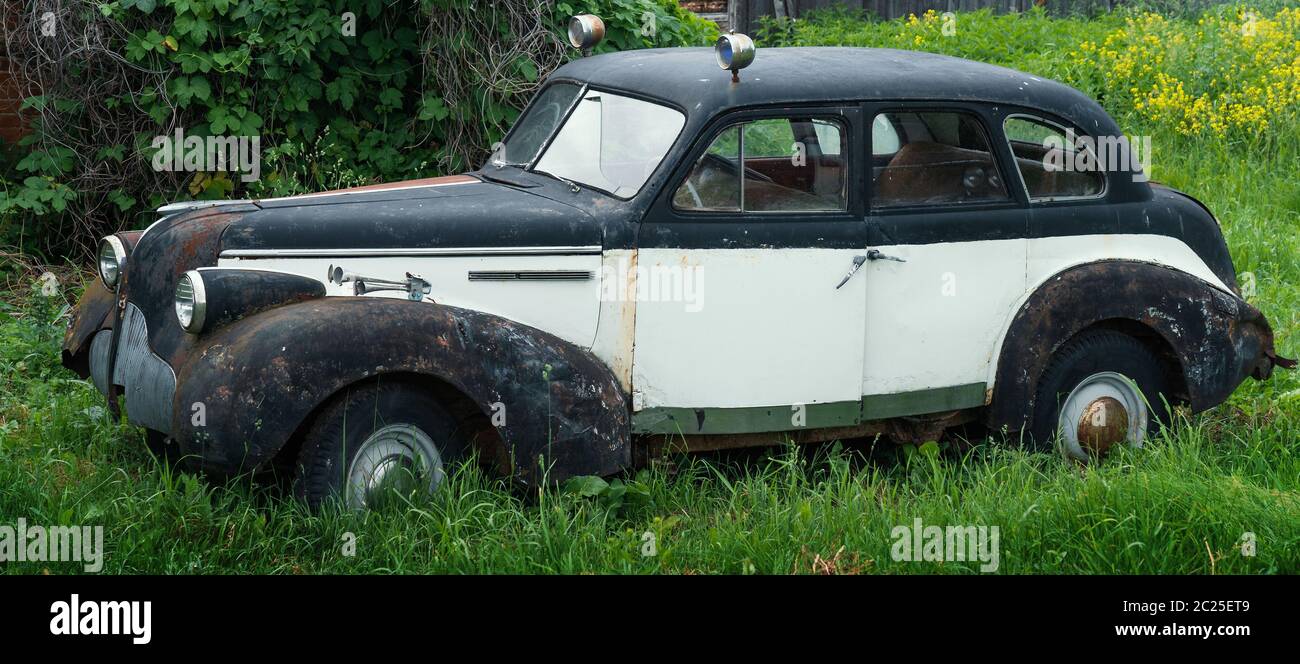 Old vintage rusty retro car in green grass Stock Photo - Alamy