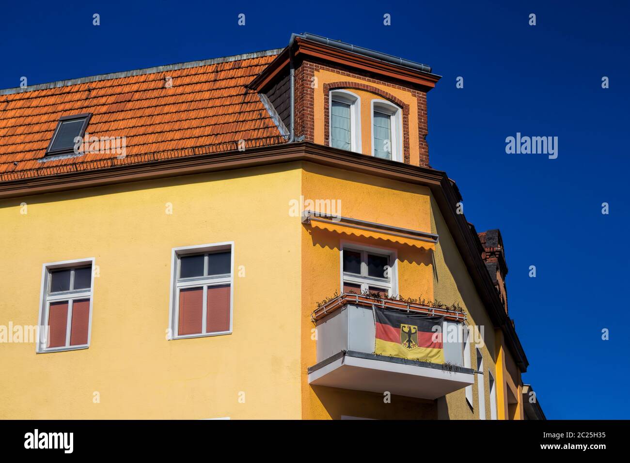 Renovated old building with German flag on the balcony in Berlin ...
