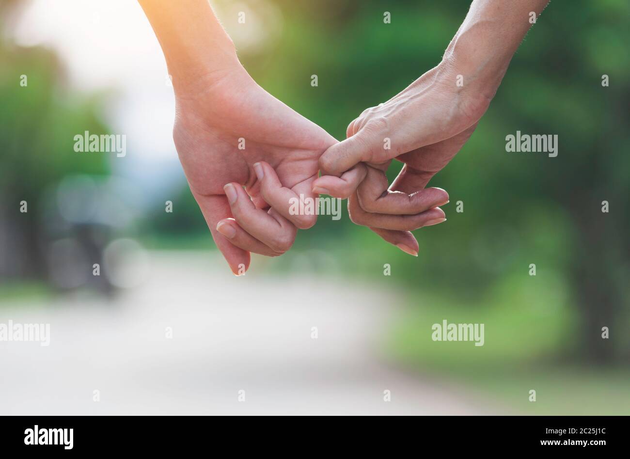 Hand of lady and younger lady holding together on blur background Stock ...