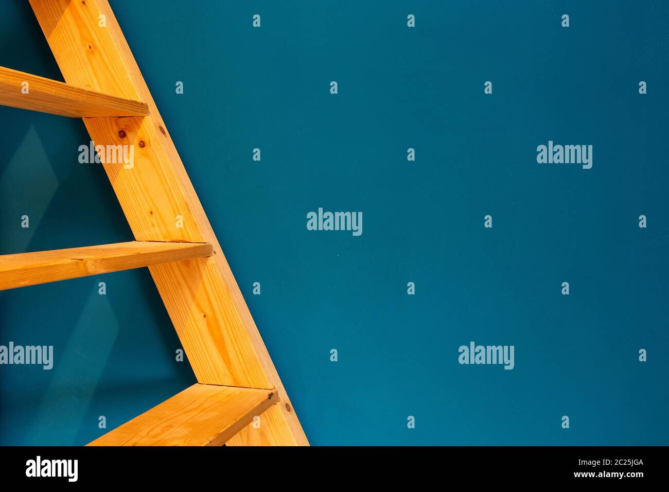 wooden yellow ladder on blue wall background. colorfull interior ...