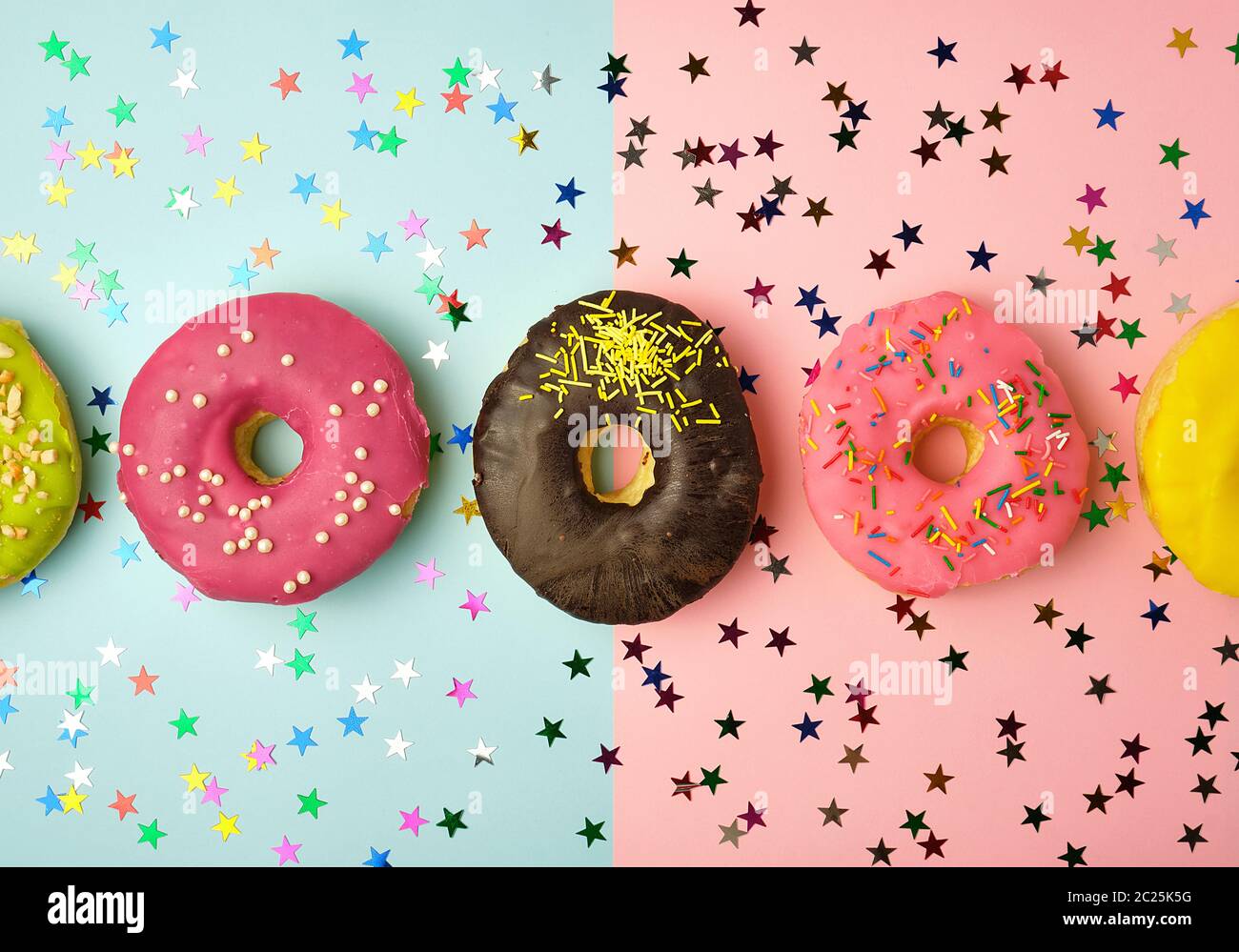 round donuts with various fillings and sprinkles on an abstract color ...