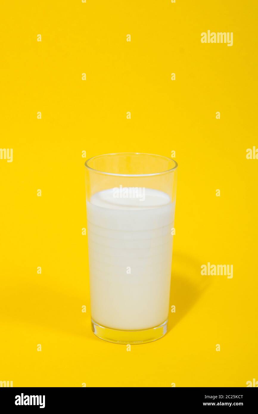 Glass of fresh milk on yellow background Stock Photo - Alamy