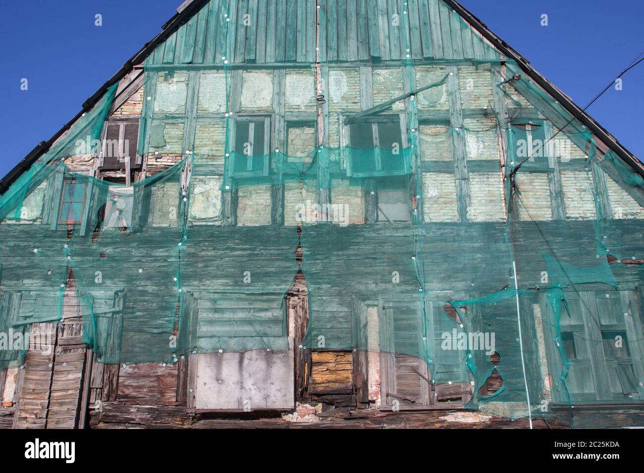 Green safety net on old building facade Stock Photo - Alamy