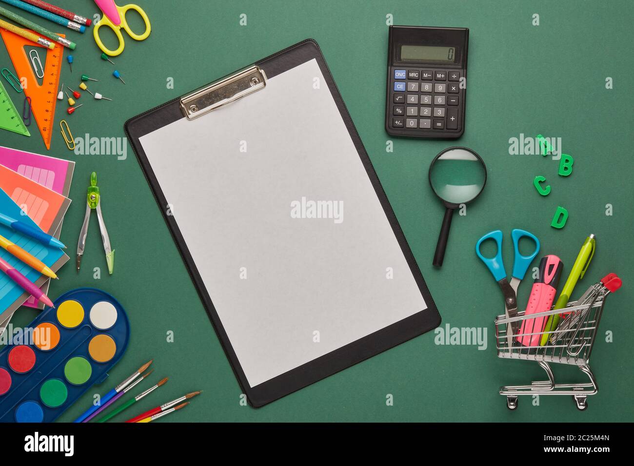 Clipboard with blank sheet, shopping trolley and stationery accessories ...