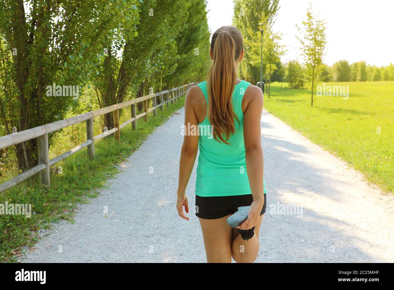 Young fitness woman runner stretching legs before run in the park Stock Photo - Alamy