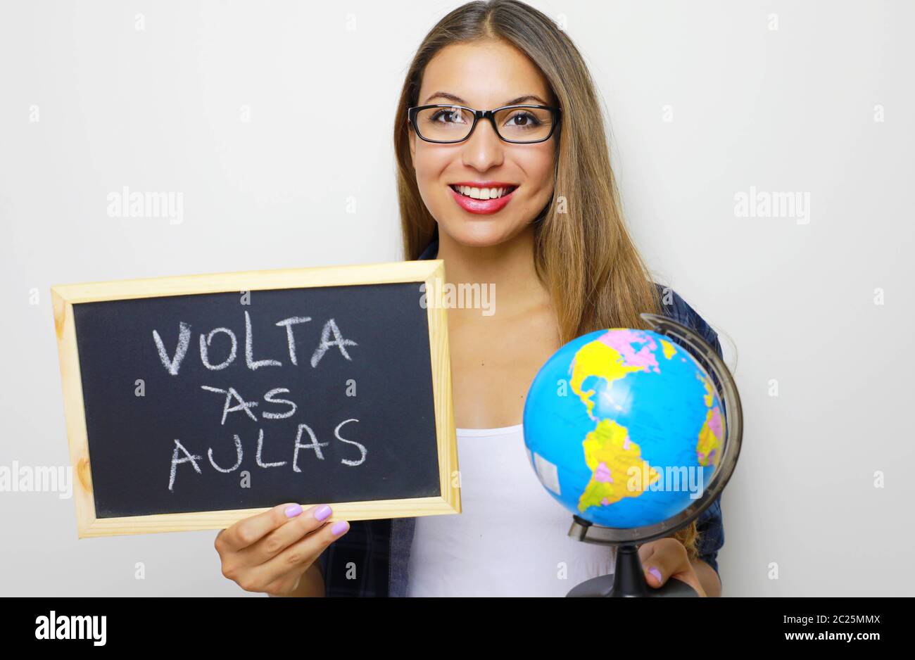 Brazilian young female teacher holding globe and blackboard with ...