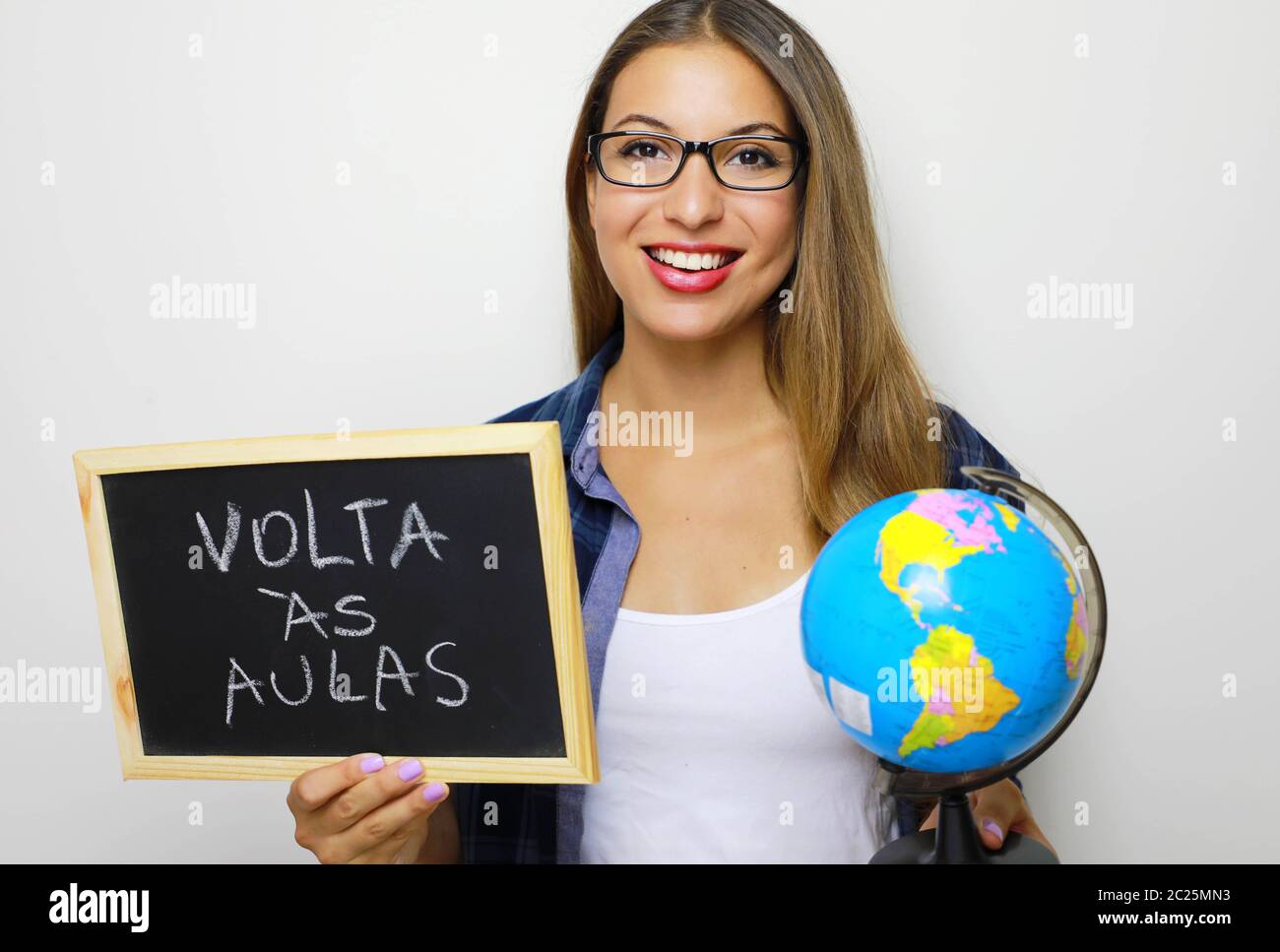 Brazilian young female teacher holding globe and blackboard with ...