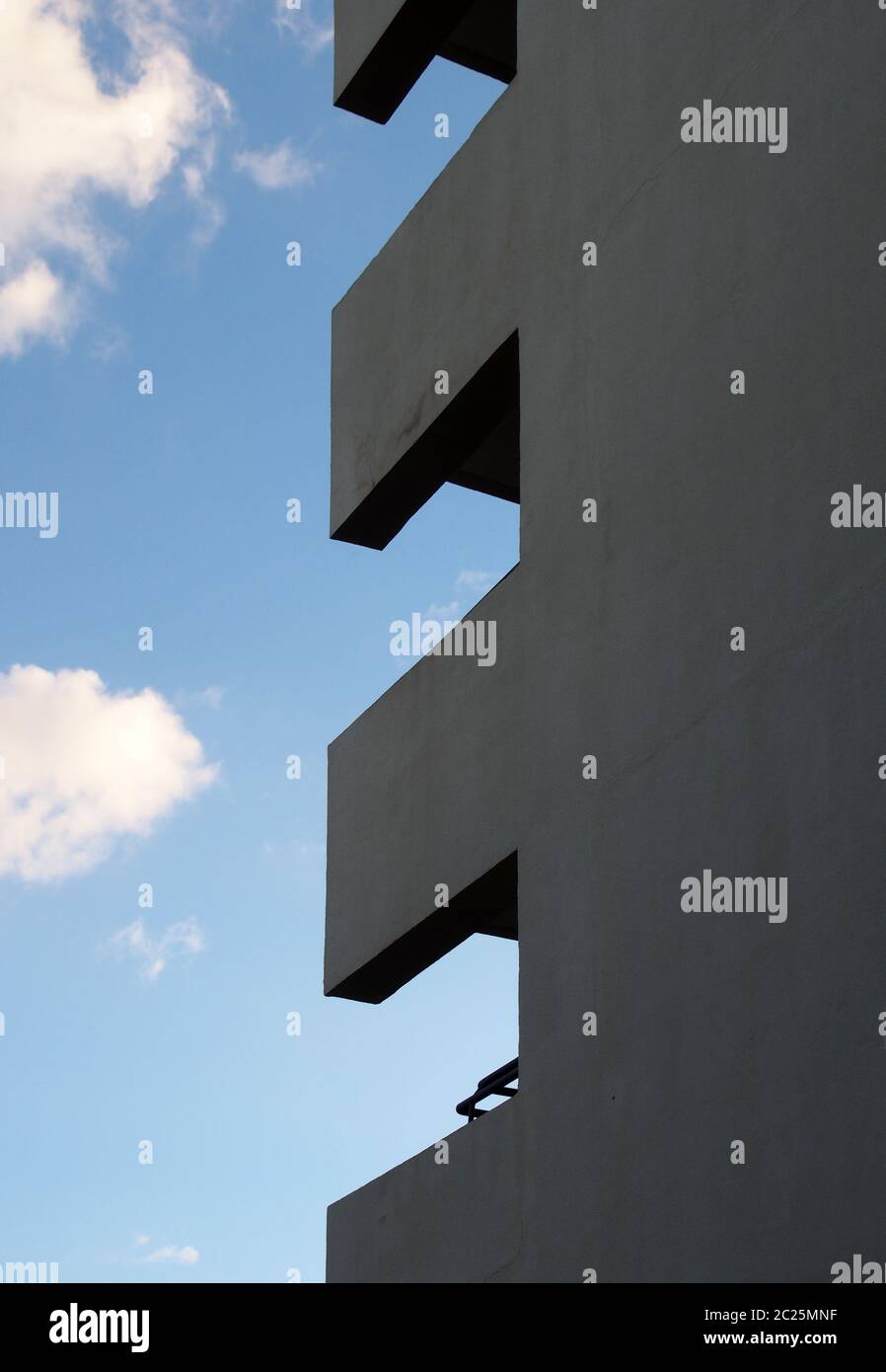 the corner of a tall apartment building with balconies forming ...