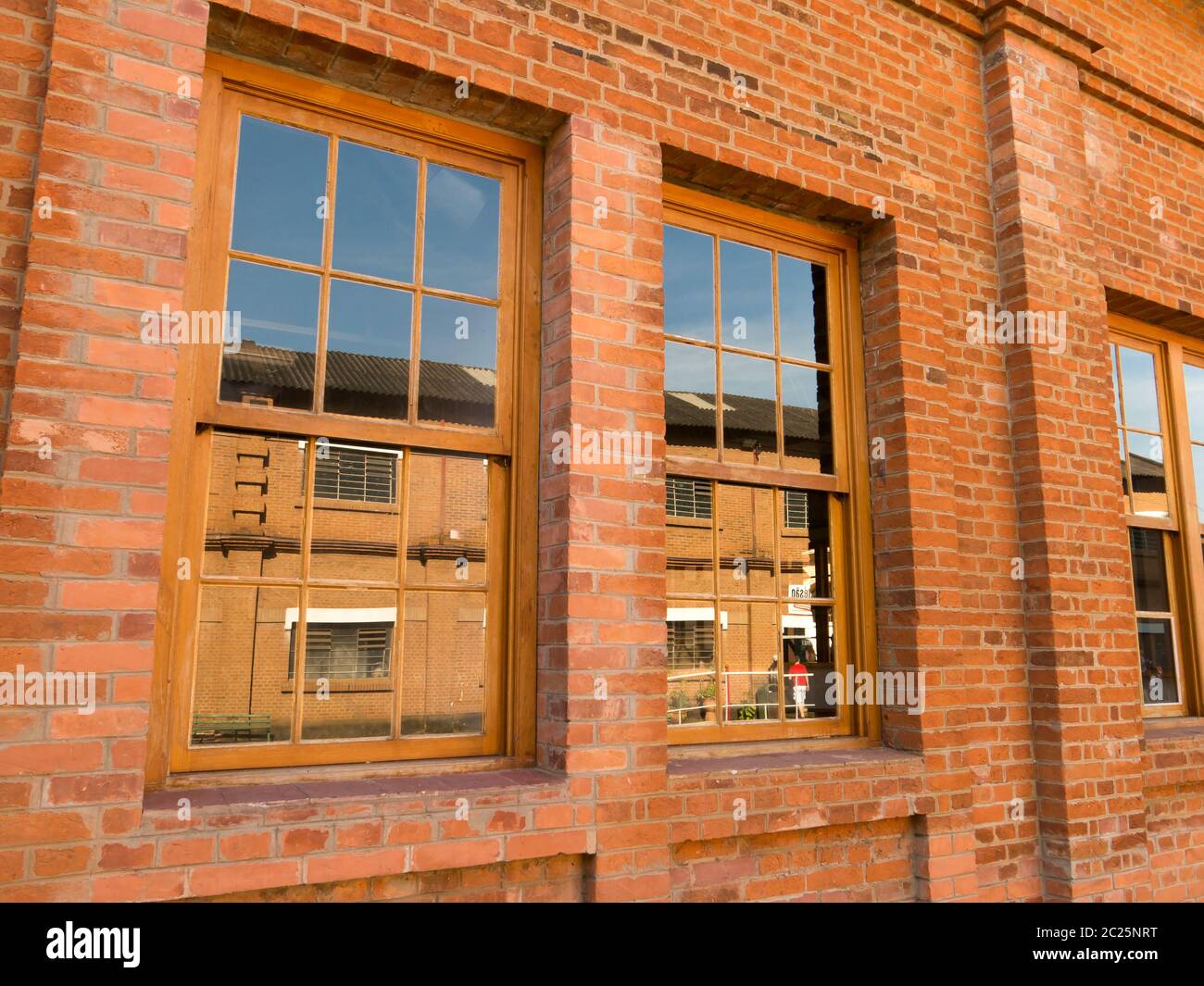 Reflections on glass windows in brick wall Stock Photo - Alamy