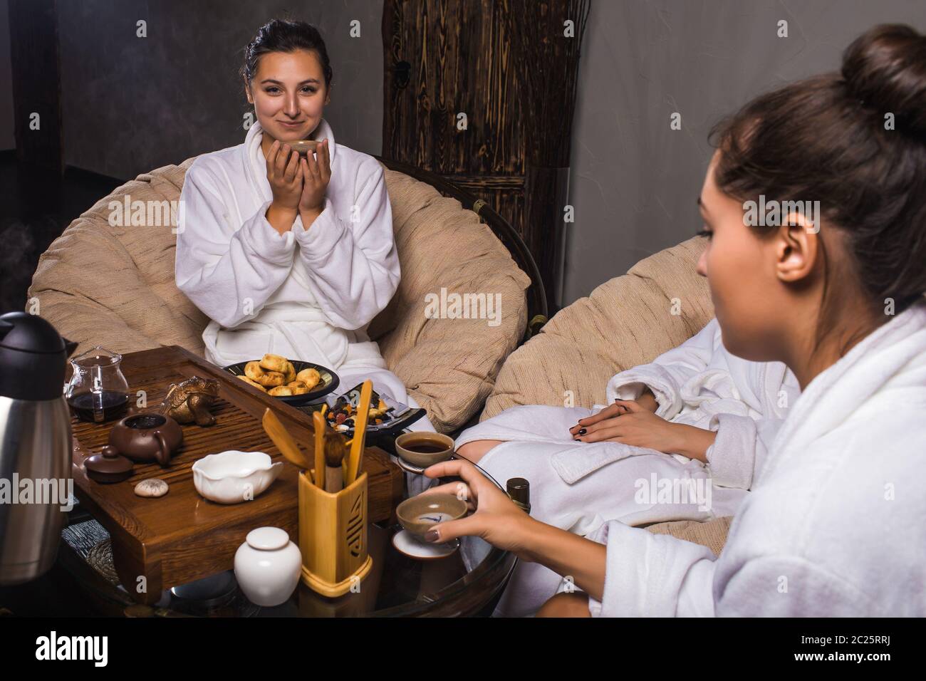 Tea ceremony after the sauna. Girls in white coats drink Chinese tea ...