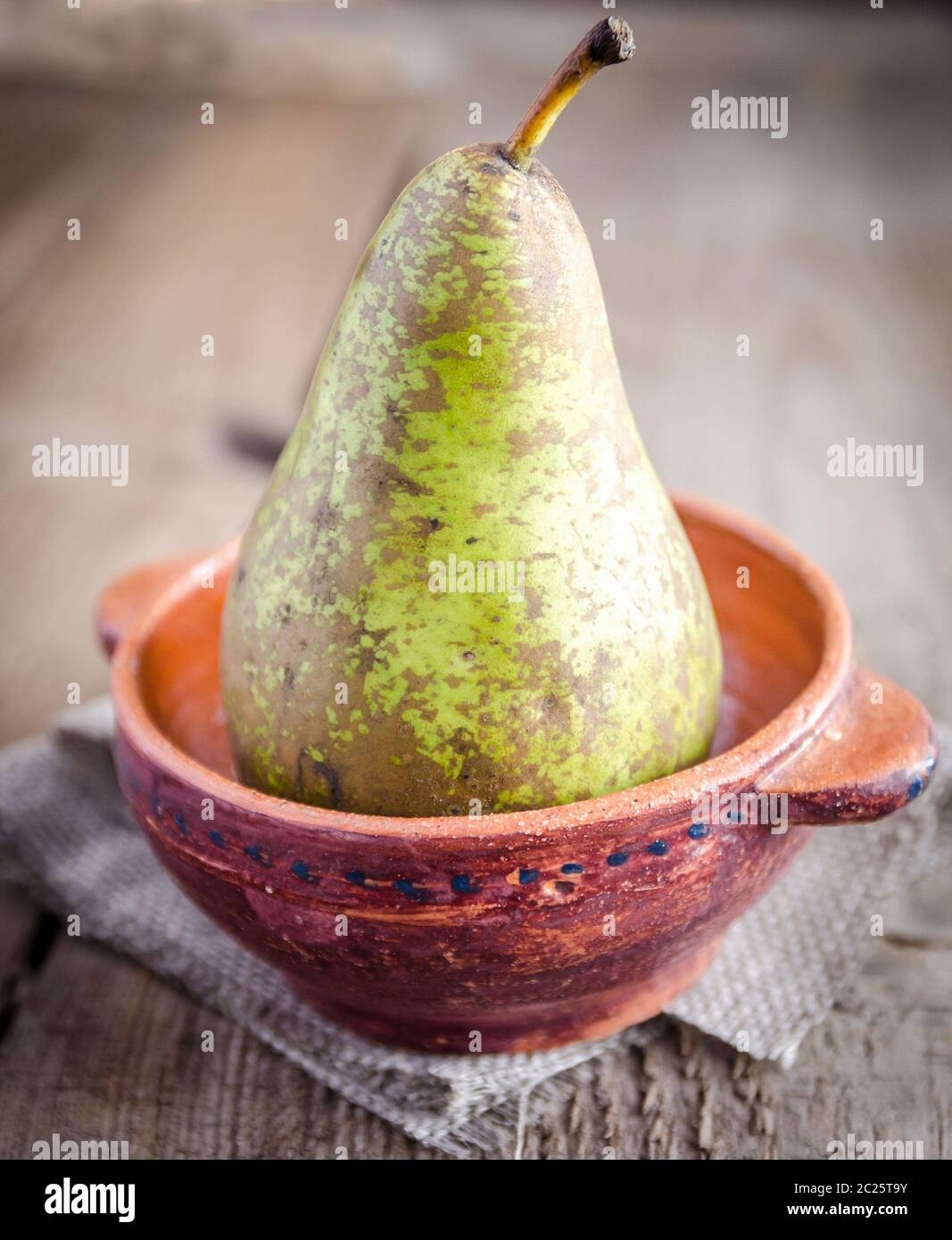 Green pear in rustic decor Stock Photo - Alamy