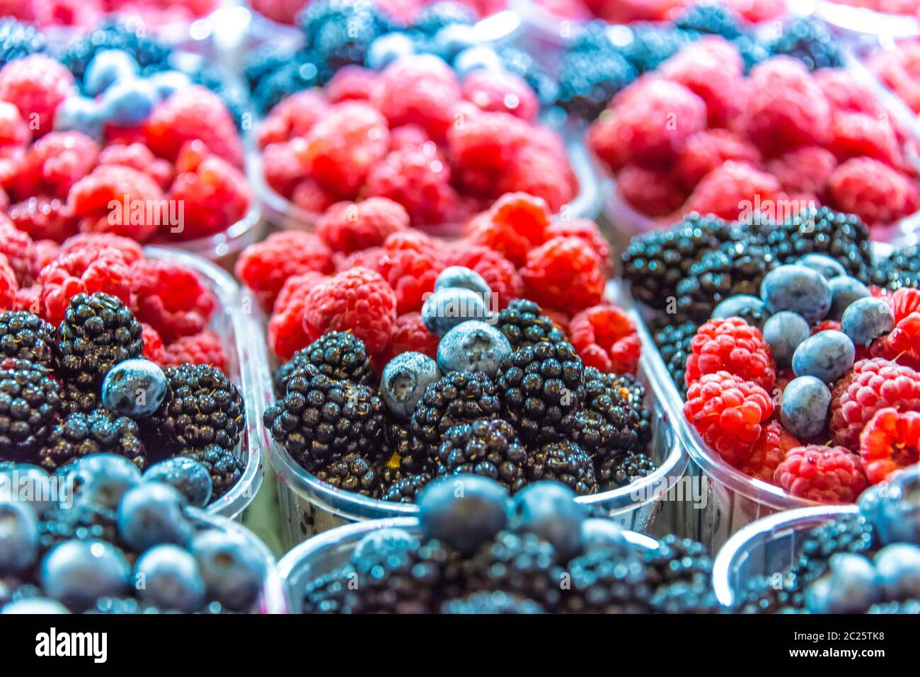 Raspberries, blueberries and blackbarries sold on the street market ...