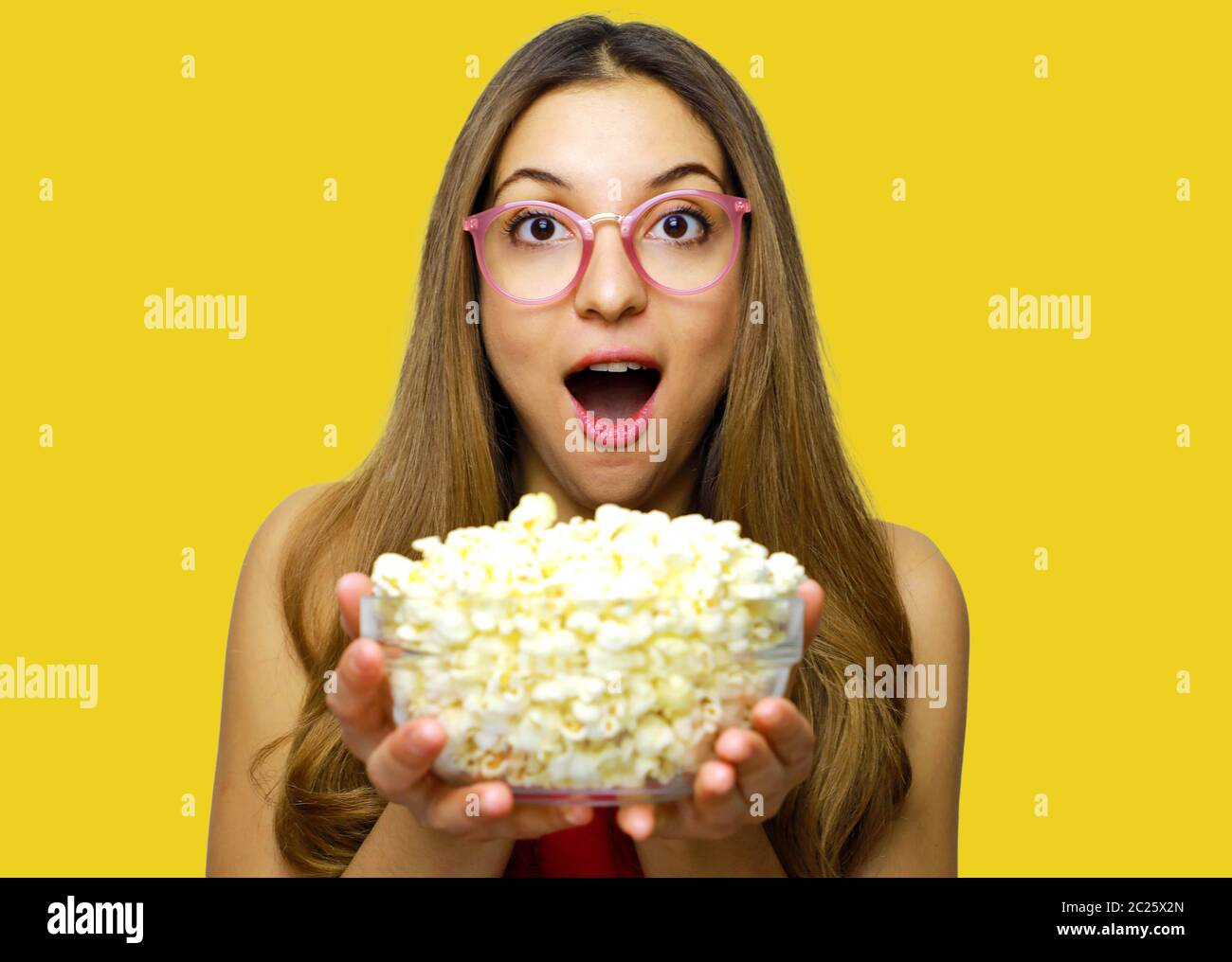 Surprised attractive young nerd woman holding pop corn bucket isolated ...