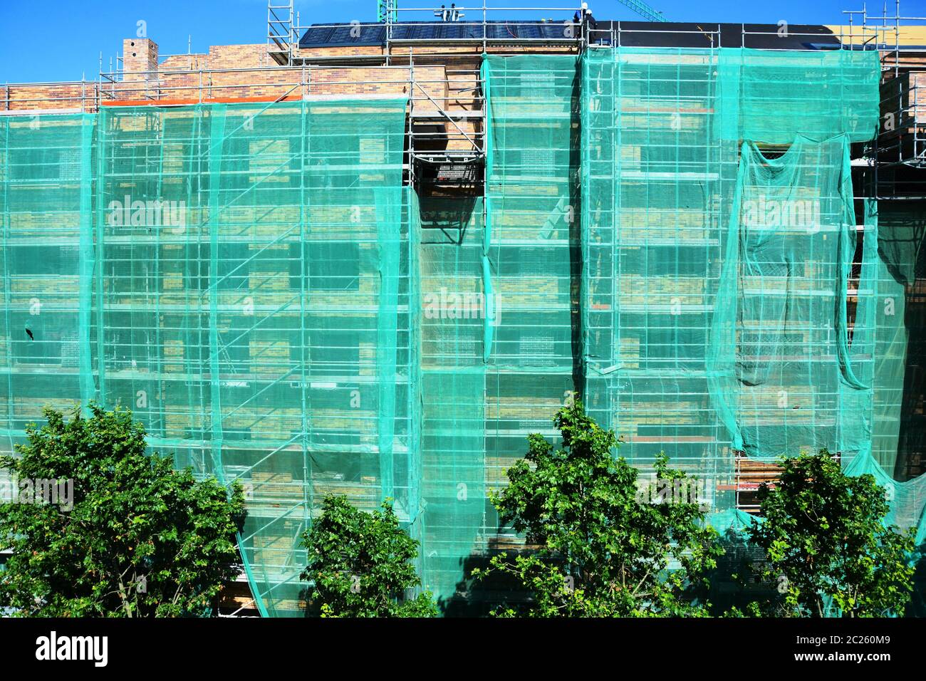building under construction with a green mesh Stock Photo - Alamy