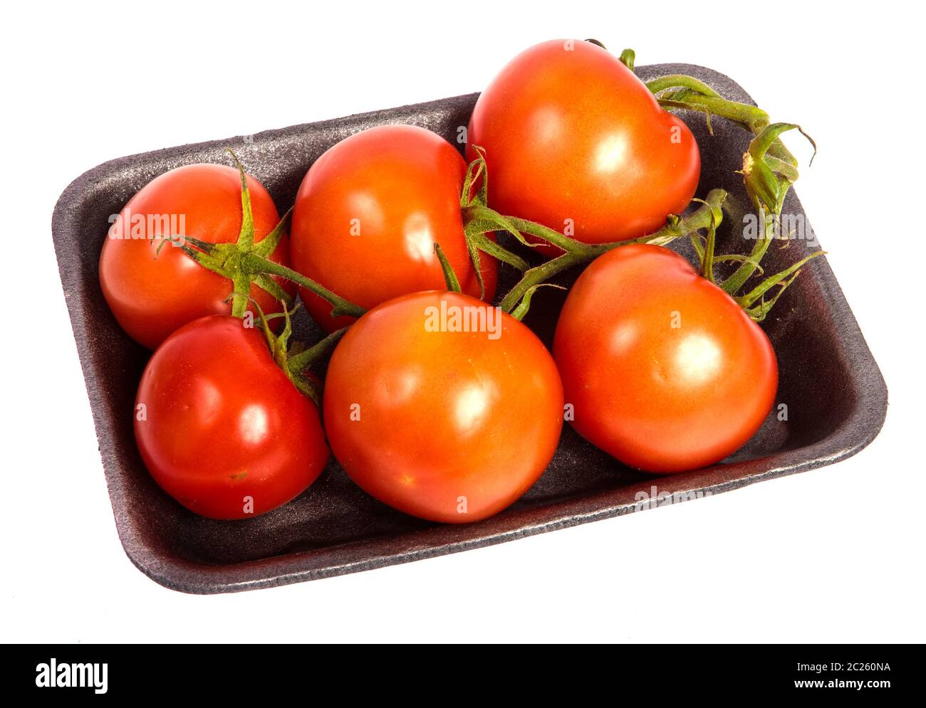 ripe red tomatoes in a dark plastic tray. on a white Stock Photo - Alamy